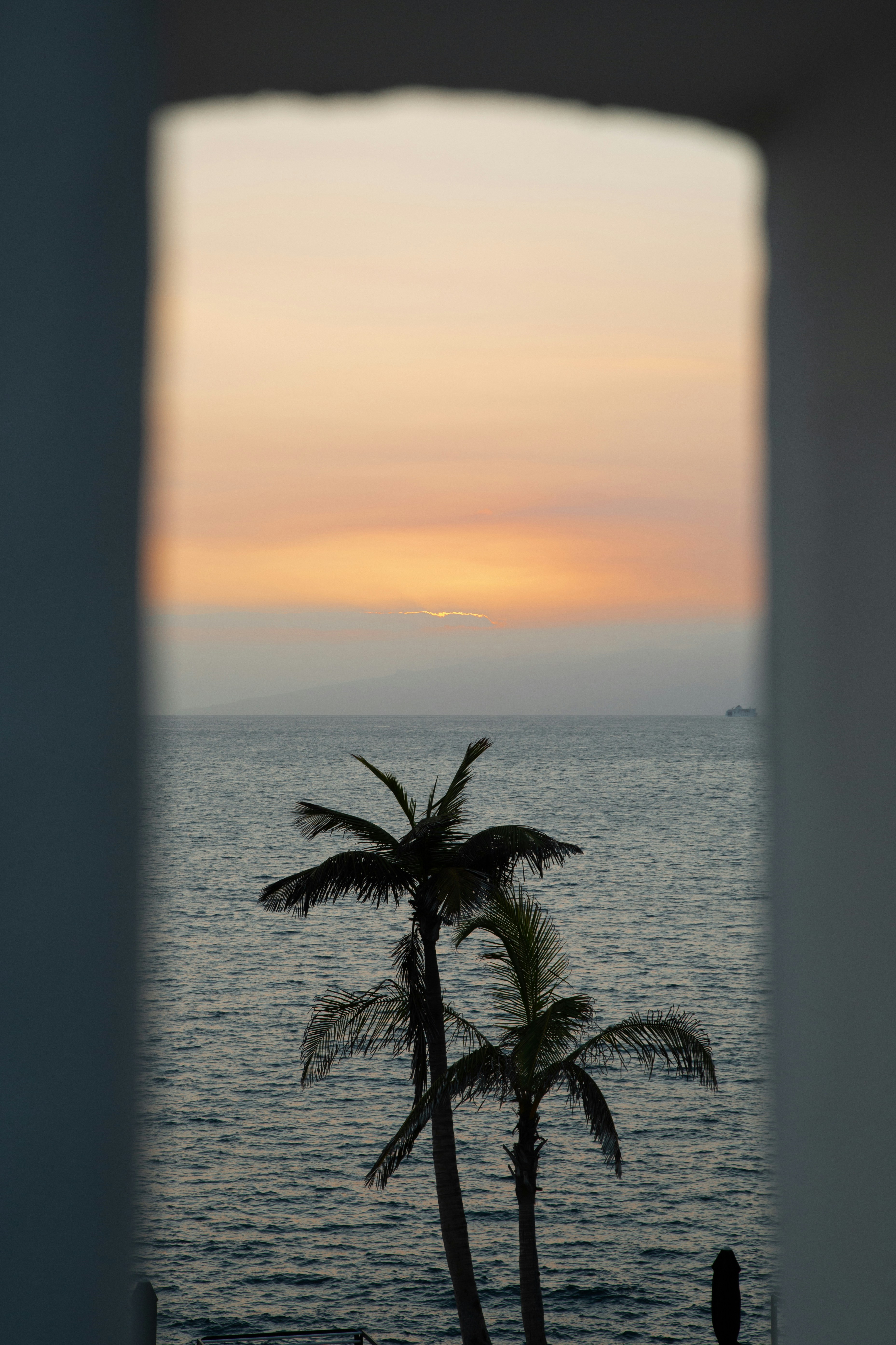 Framed Sunset Over Calm Seas Through a Balcony Arch