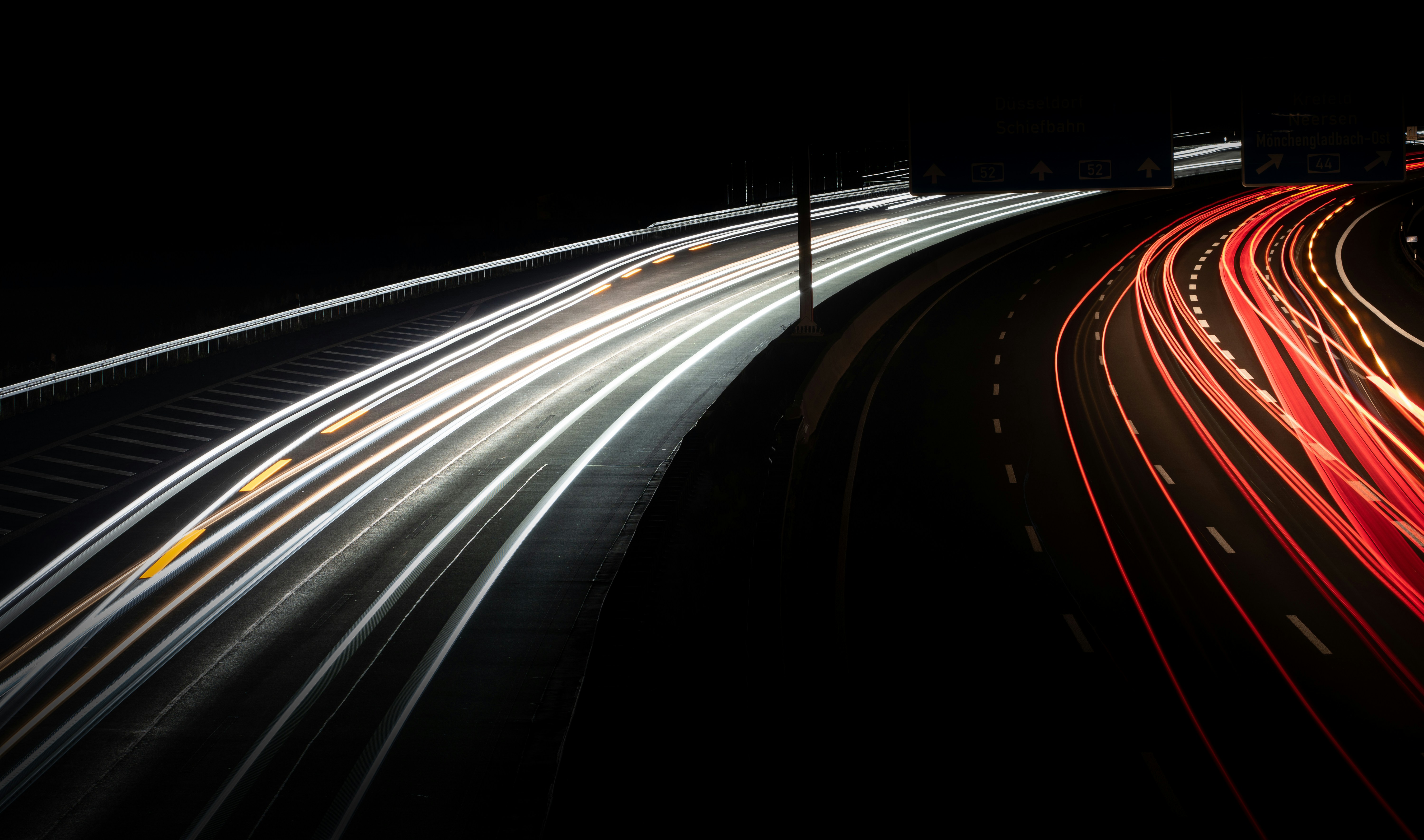 a long exposure photo of a highway at night