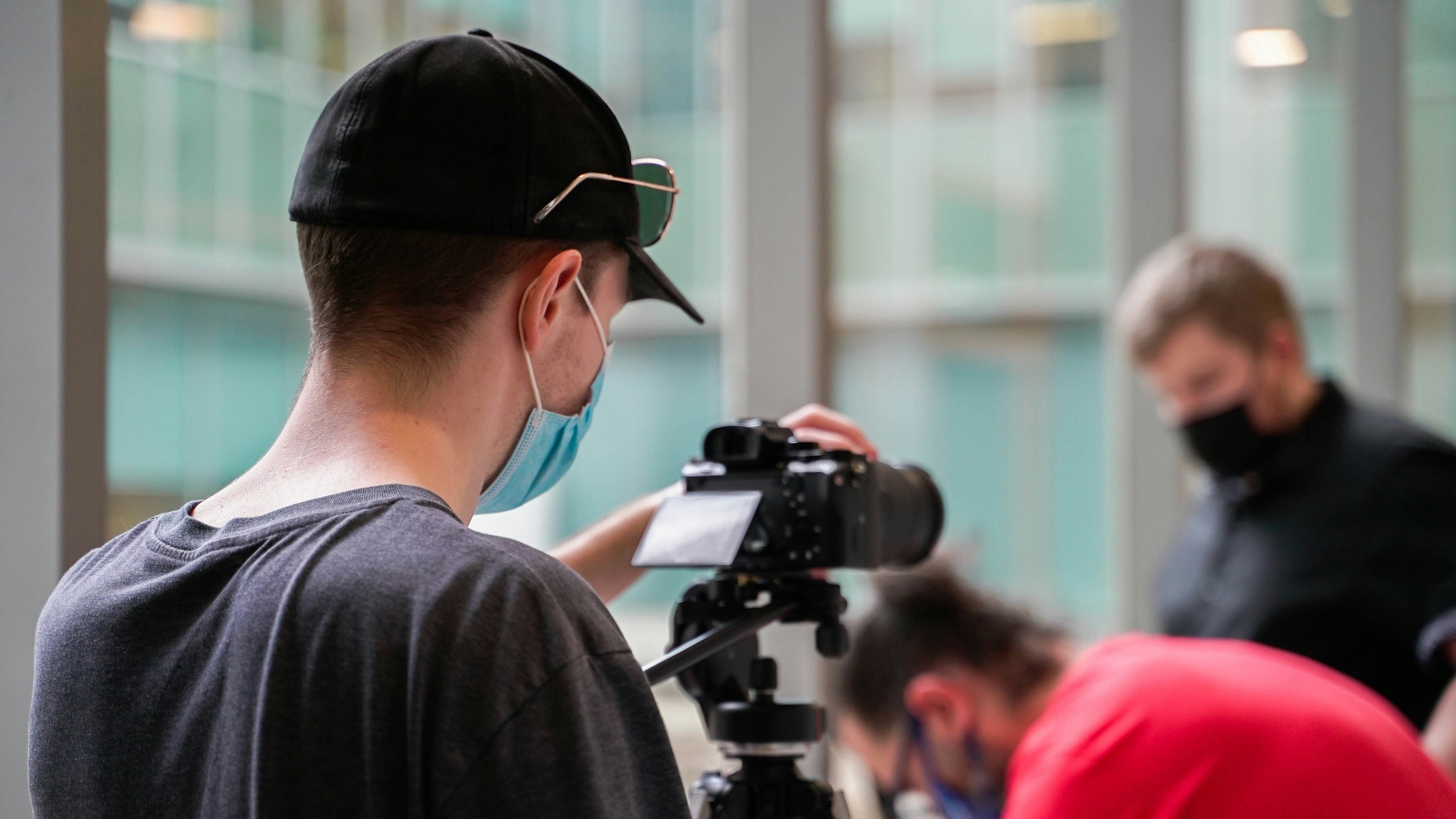 A man wearing a face mask while filming another man photo – Free Tripod ...