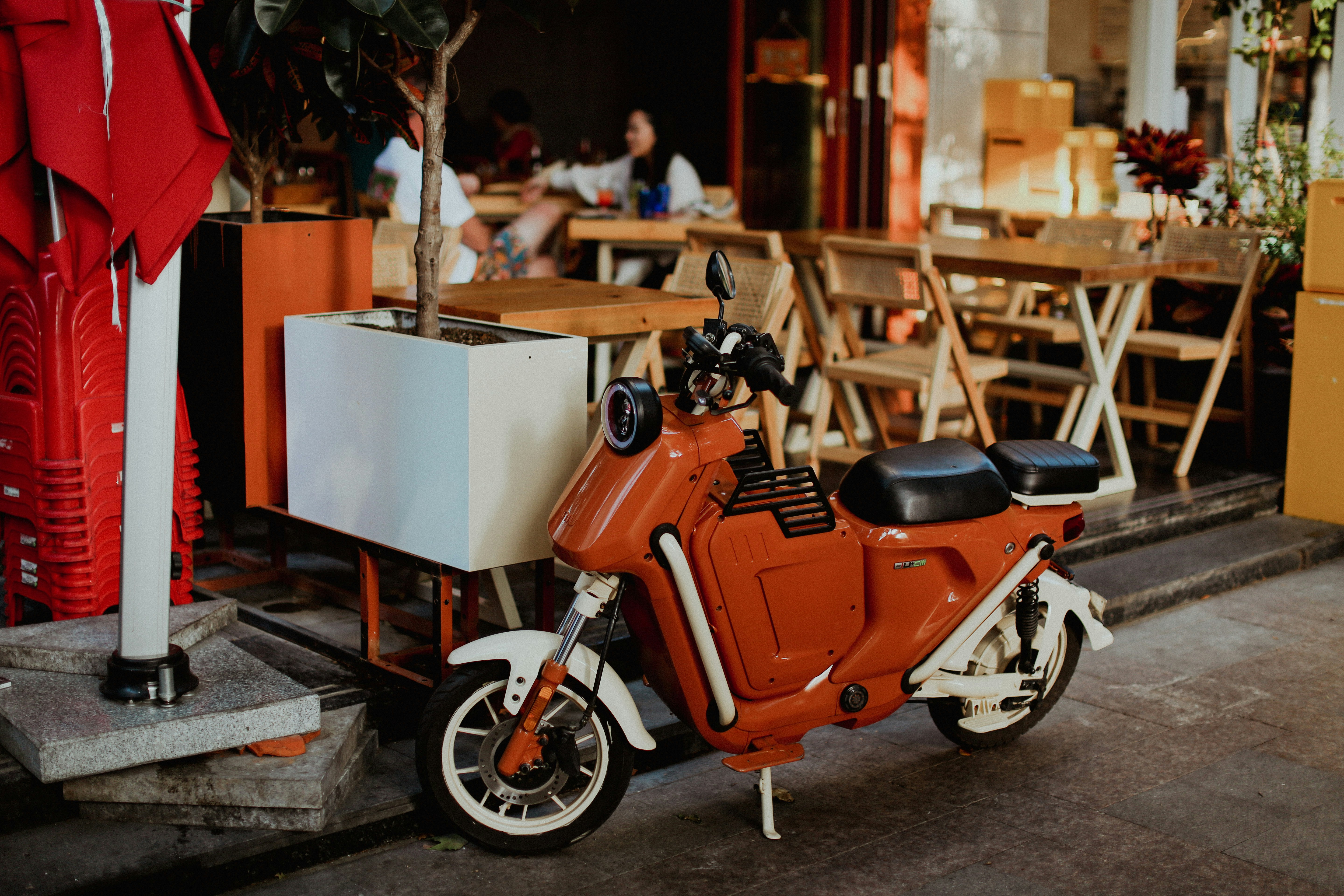 An orange scooter parked in front of a restaurant photo – Free Street ...