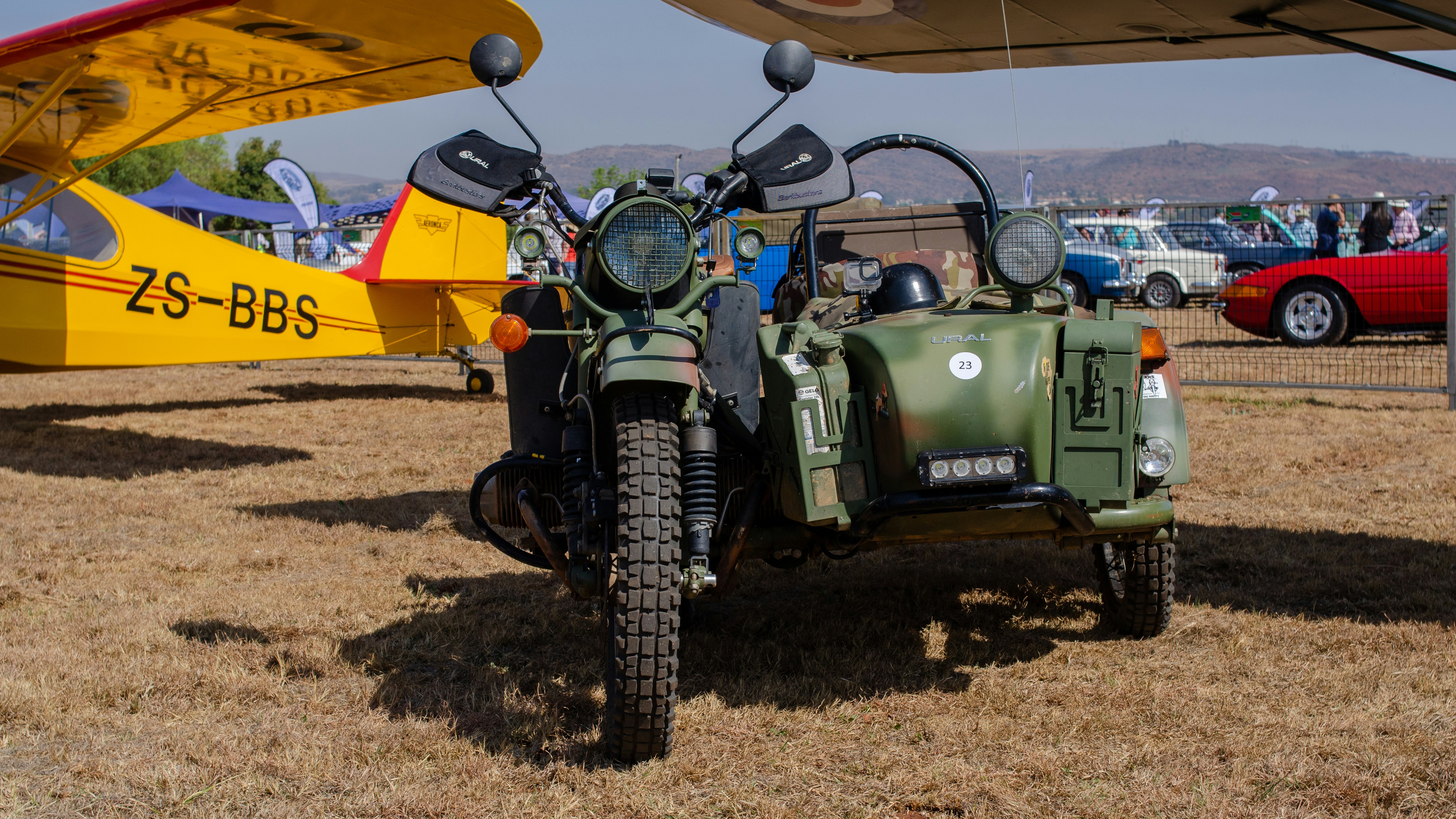 A green motorcycle parked next to a yellow plane photo – Free Human ...