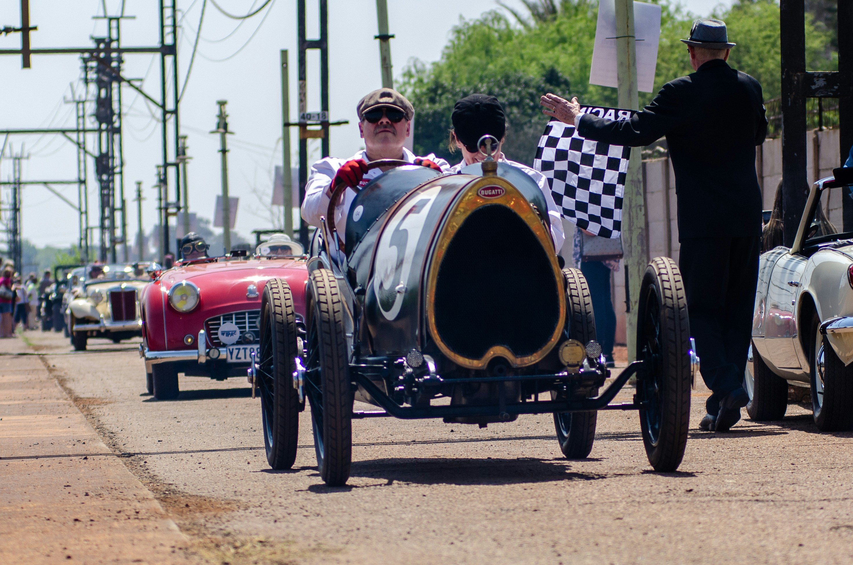 Front-Row Open-Cockpit Racer Leads a Dusty Vintage Car Parade