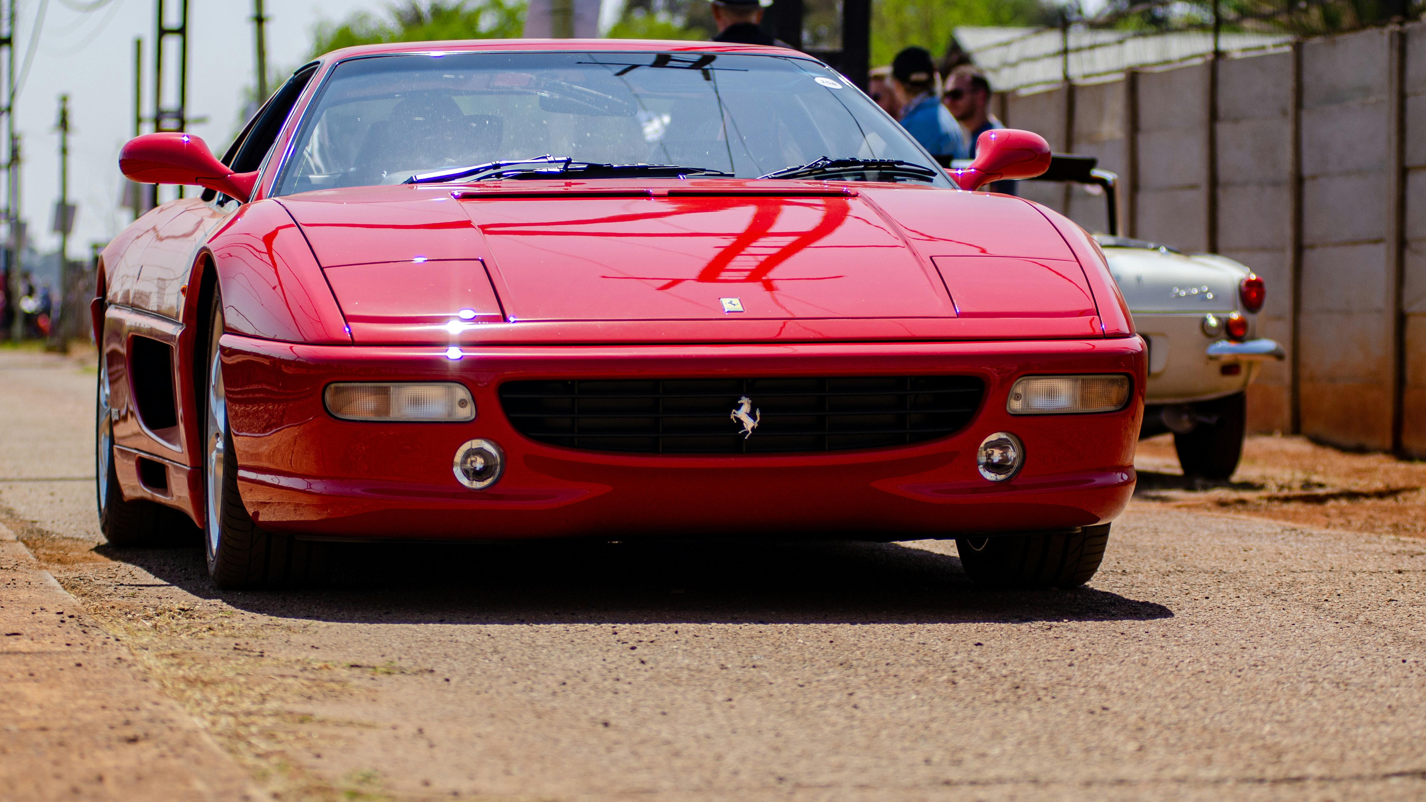 Red Ferrari on a Sunlit Street: Front View and Motion Cues