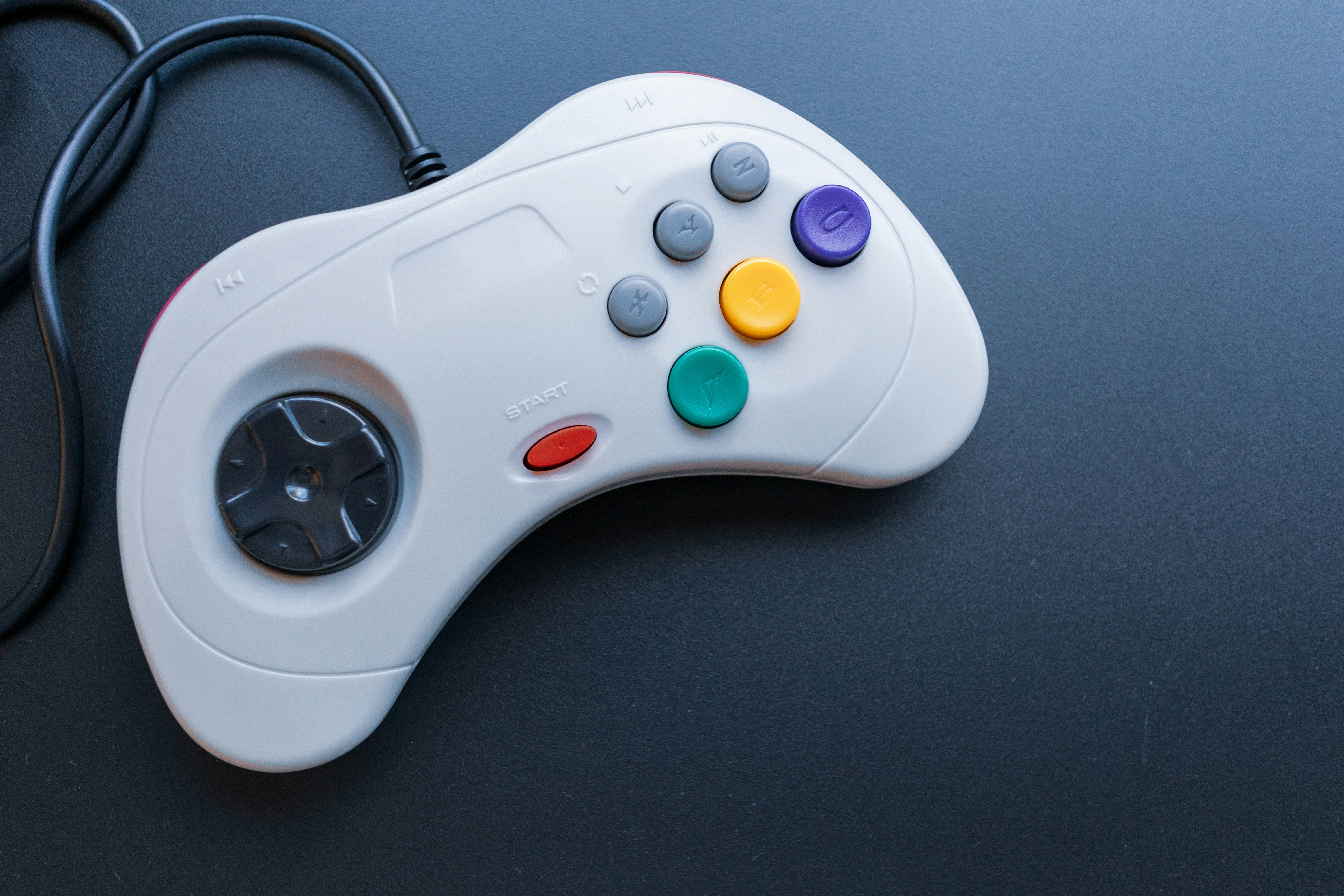 A video game controller sitting on top of a table photo – Free ...