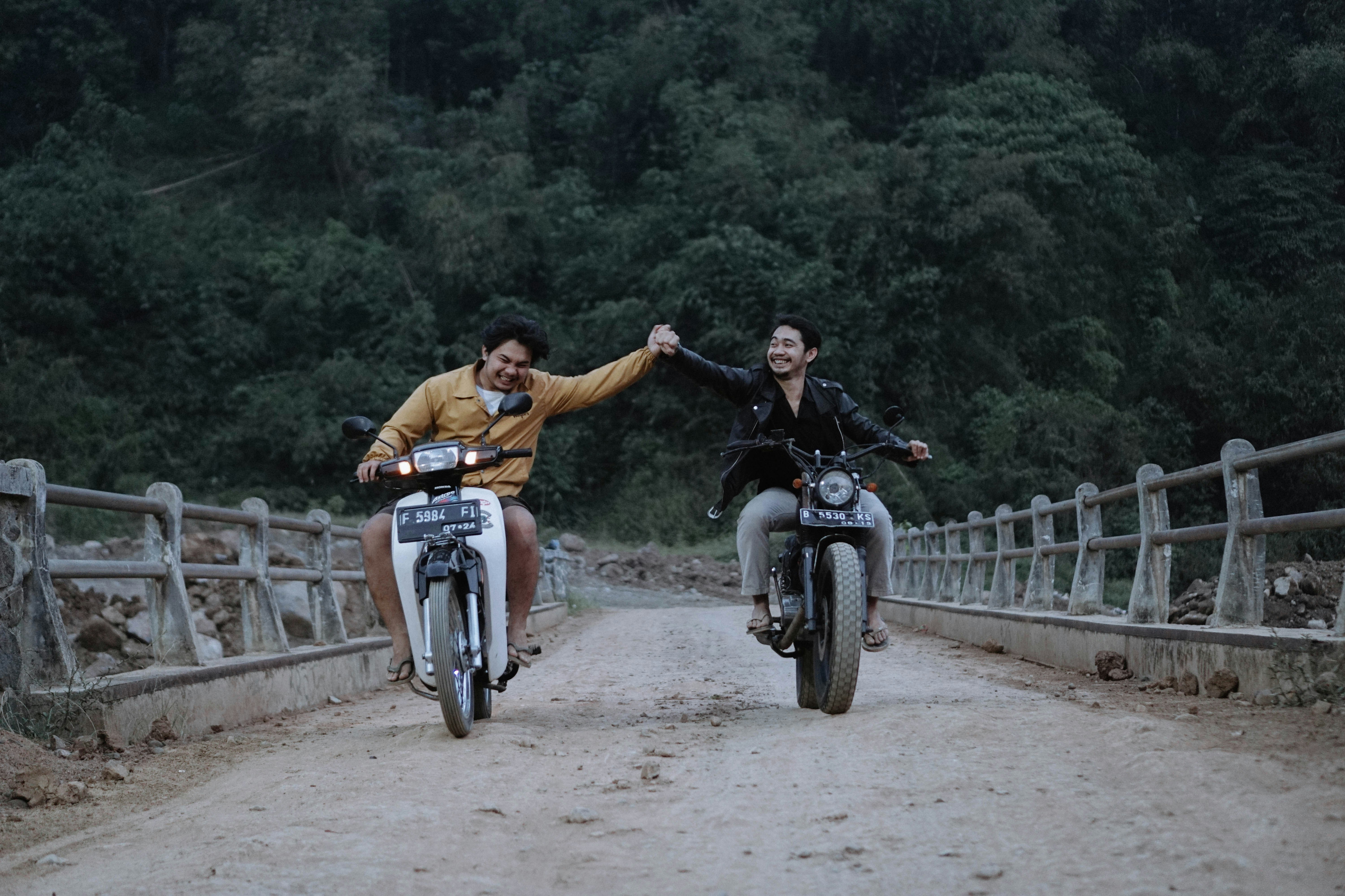 a couple of people riding on the back of motorcycles