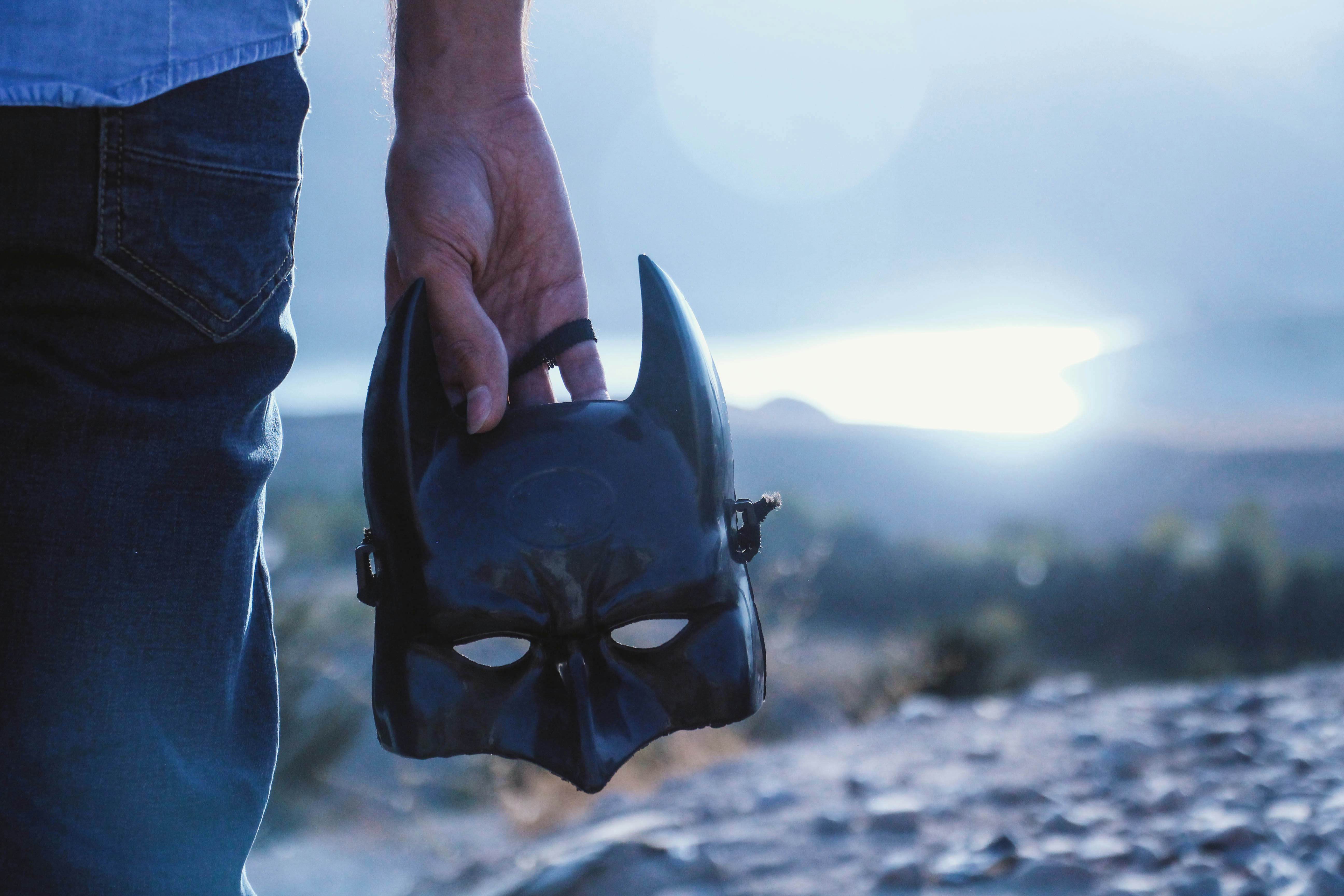 A person holding a batman mask in their hand photo – Free City Image on ...