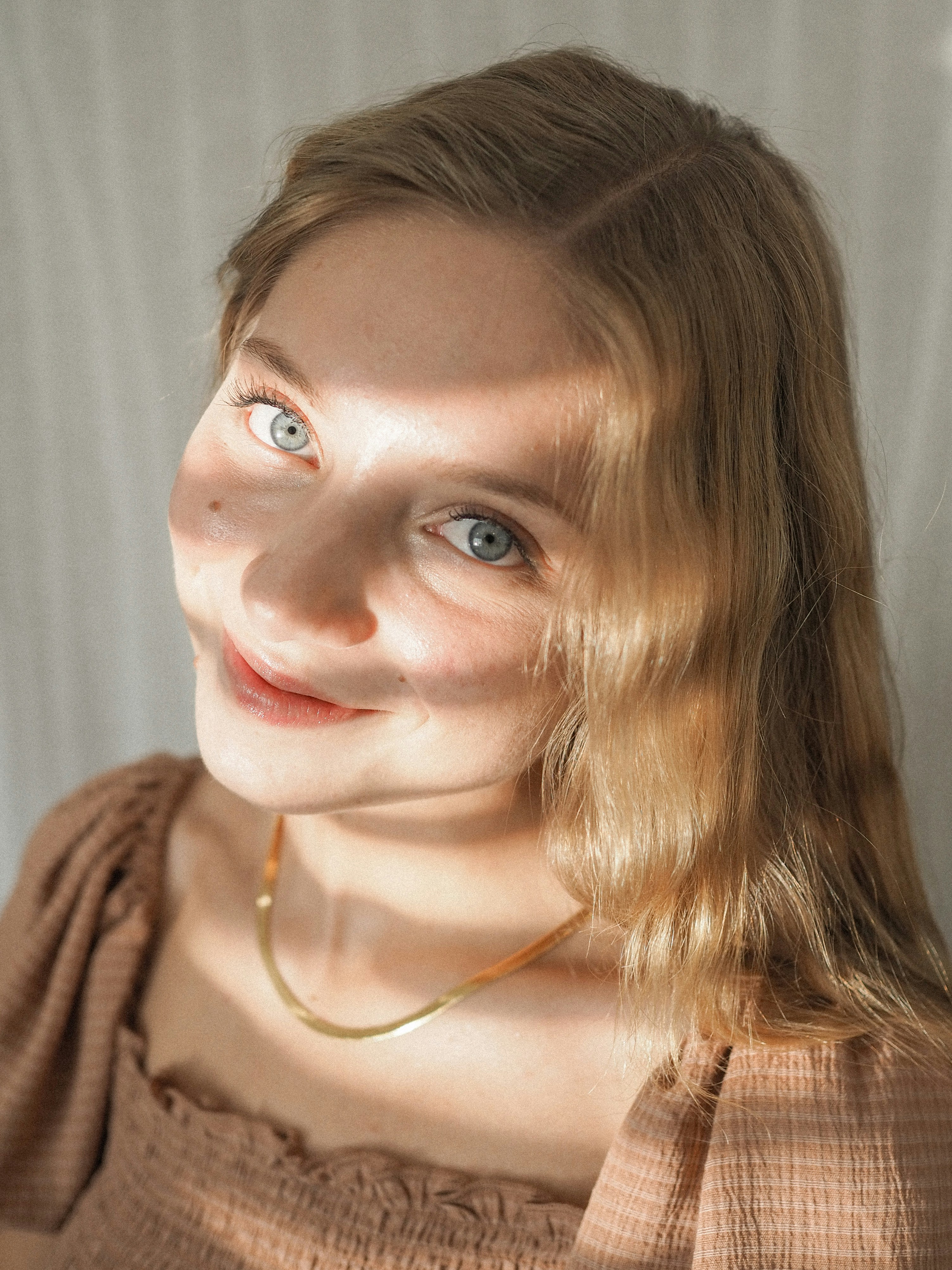 Striped Sunlight Portrait: Blue-Eyed Gaze in Warm Strands