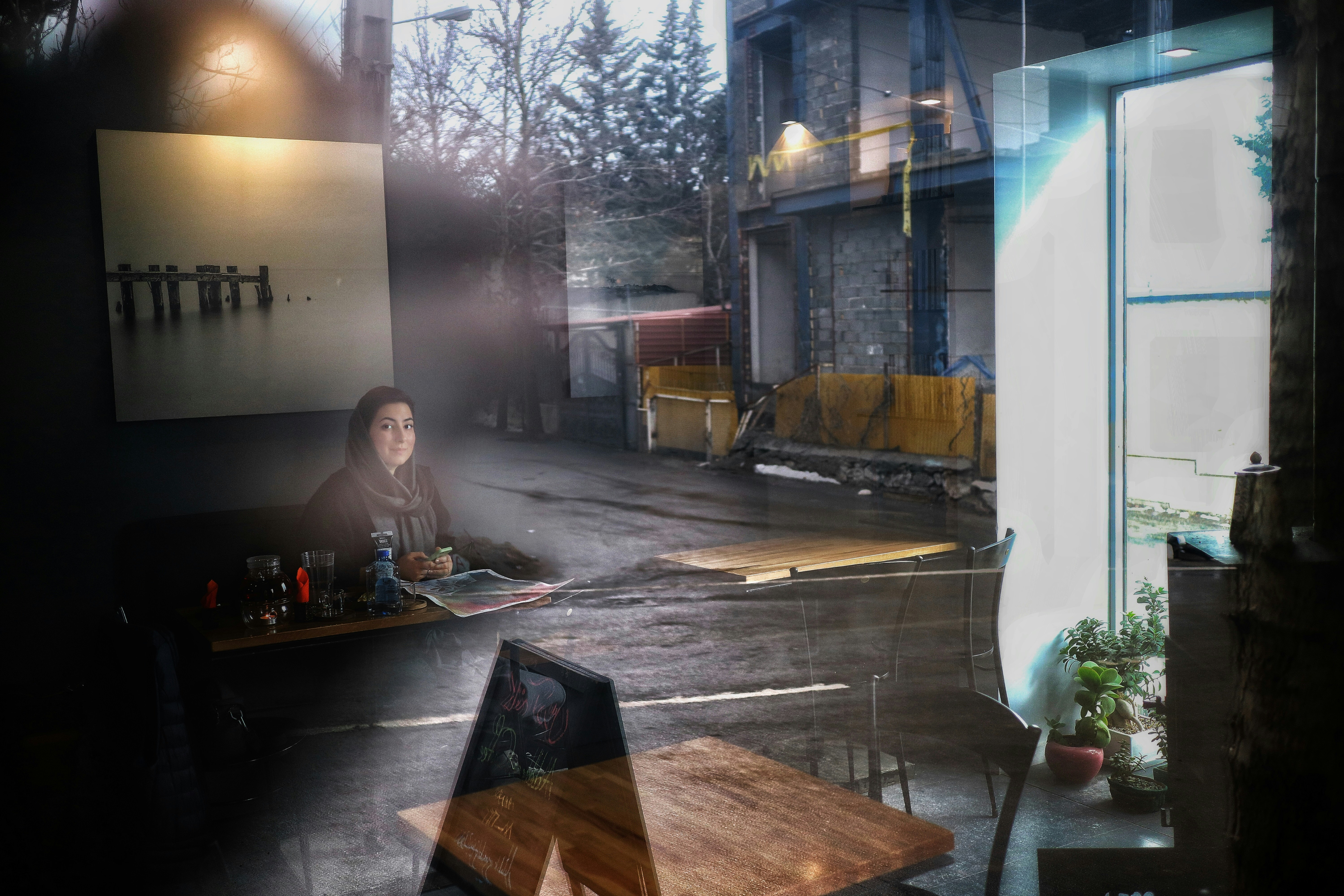 a woman sitting at a table in front of a window