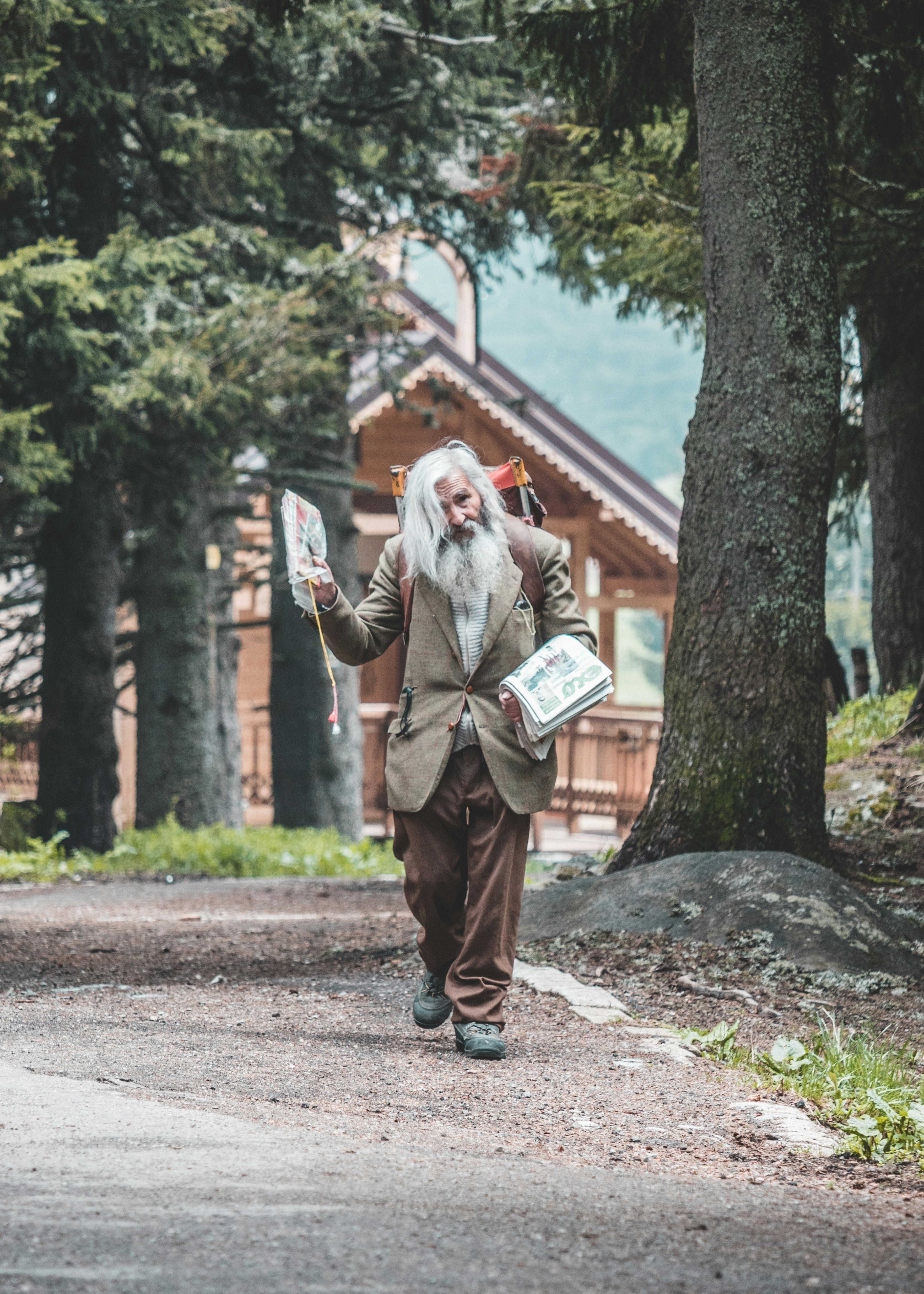 Bearded Messenger in the Pines: Newspapers in Tow on a Quiet Forest Path