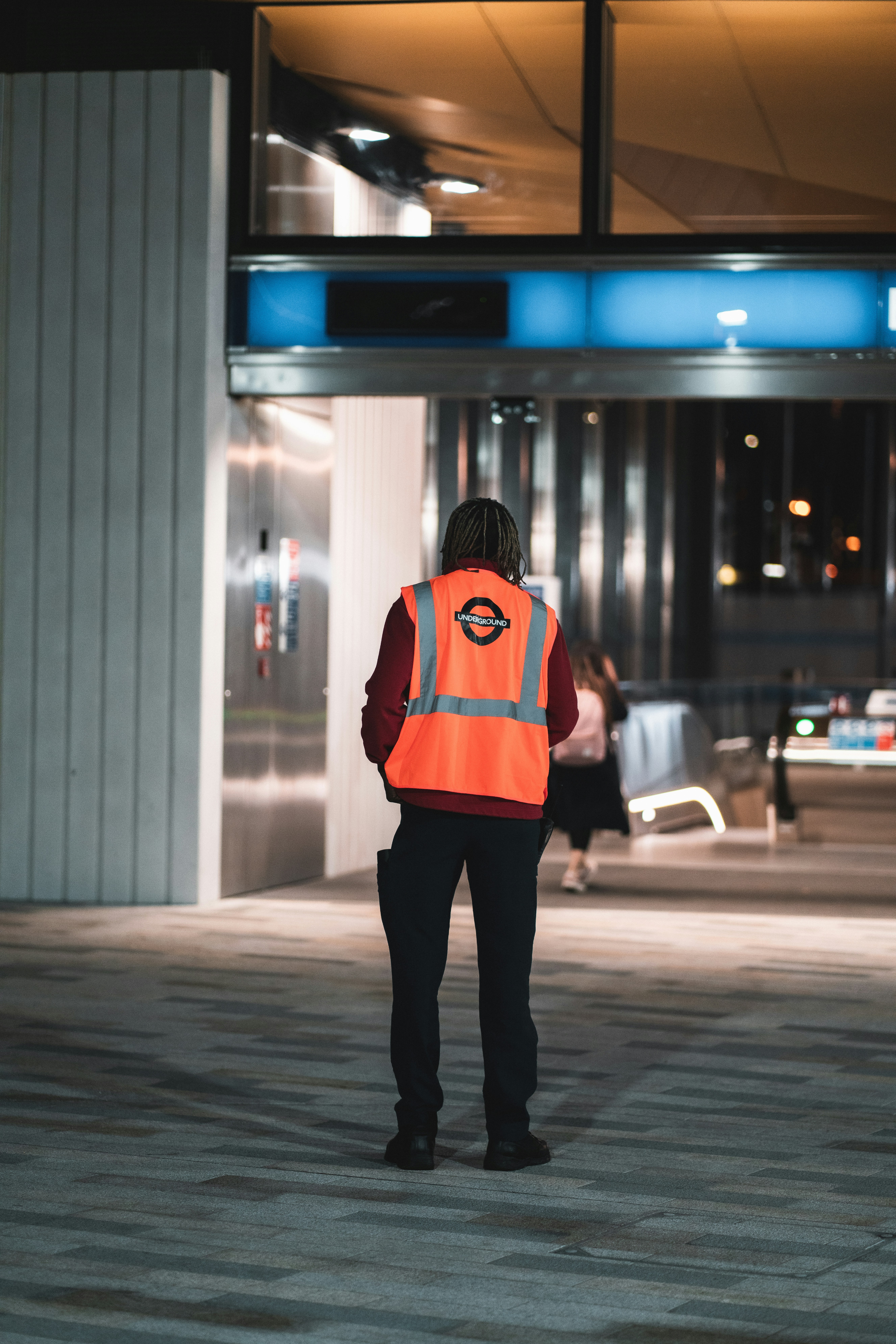 Night Gatekeeper: Fluorescent Orange at the Glass Entrance