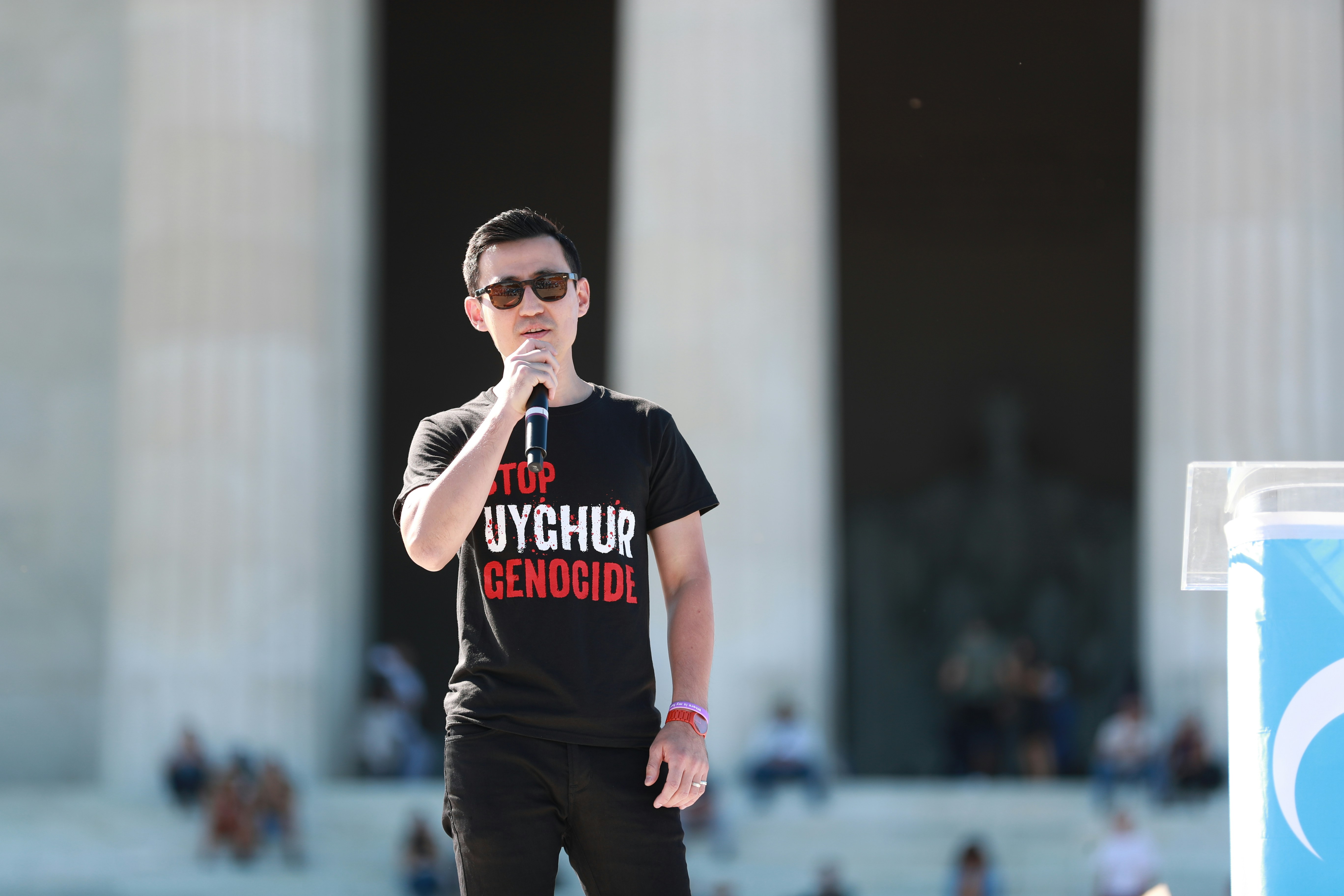 Voice Under Marble Columns: Protester with Bold Shirt Delivers Speech