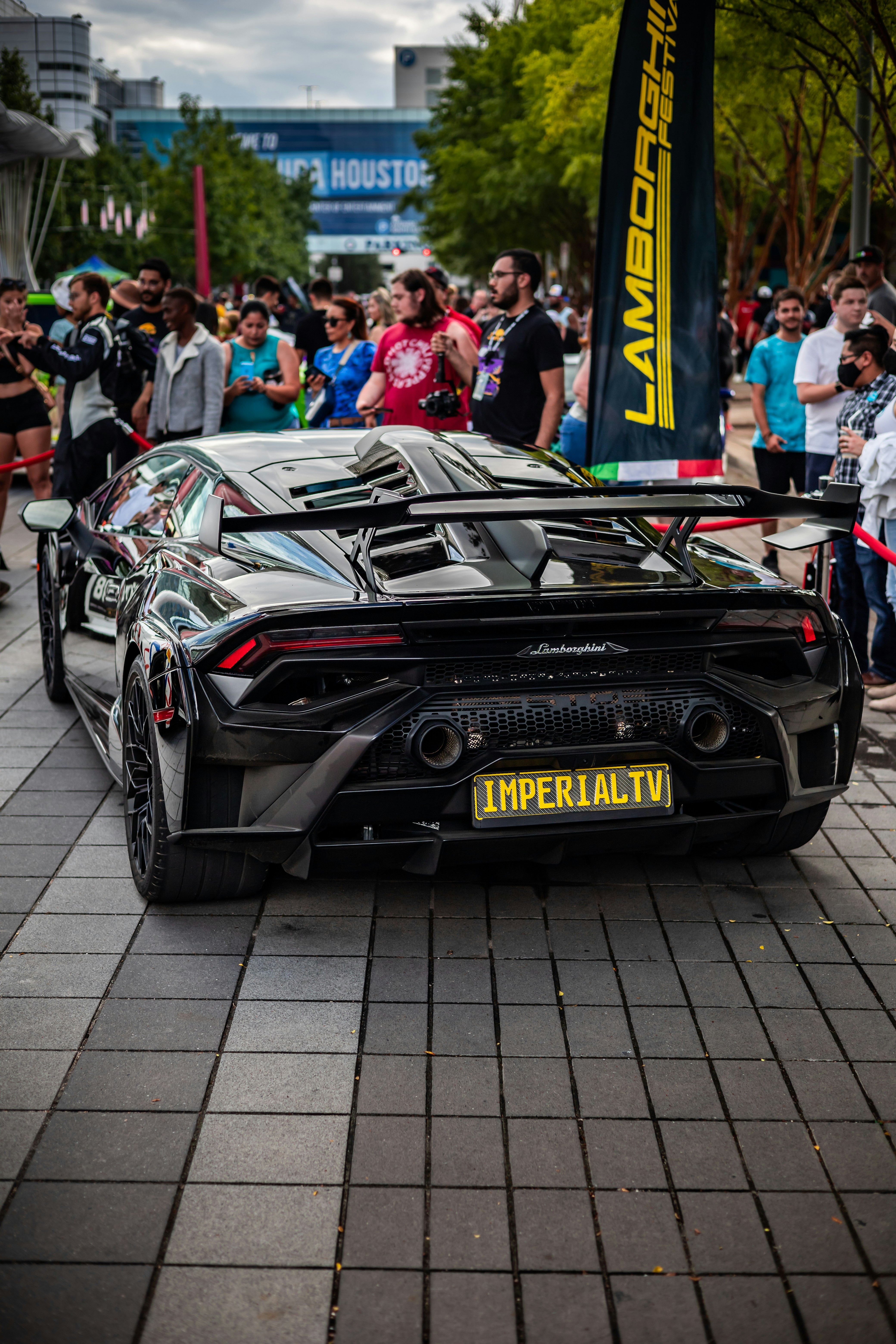 A black sports car parked in front of a crowd of people photo – Free ...