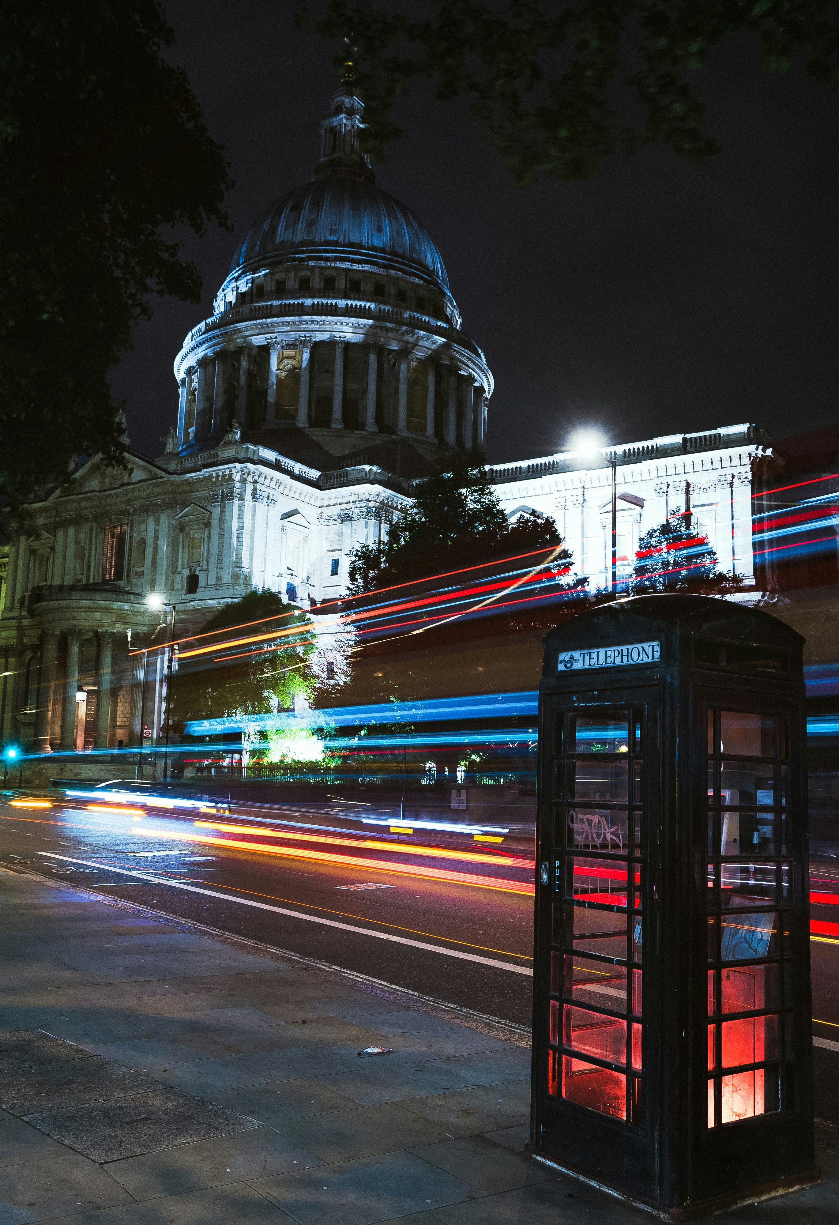 a telephone booth sitting on the side of a road