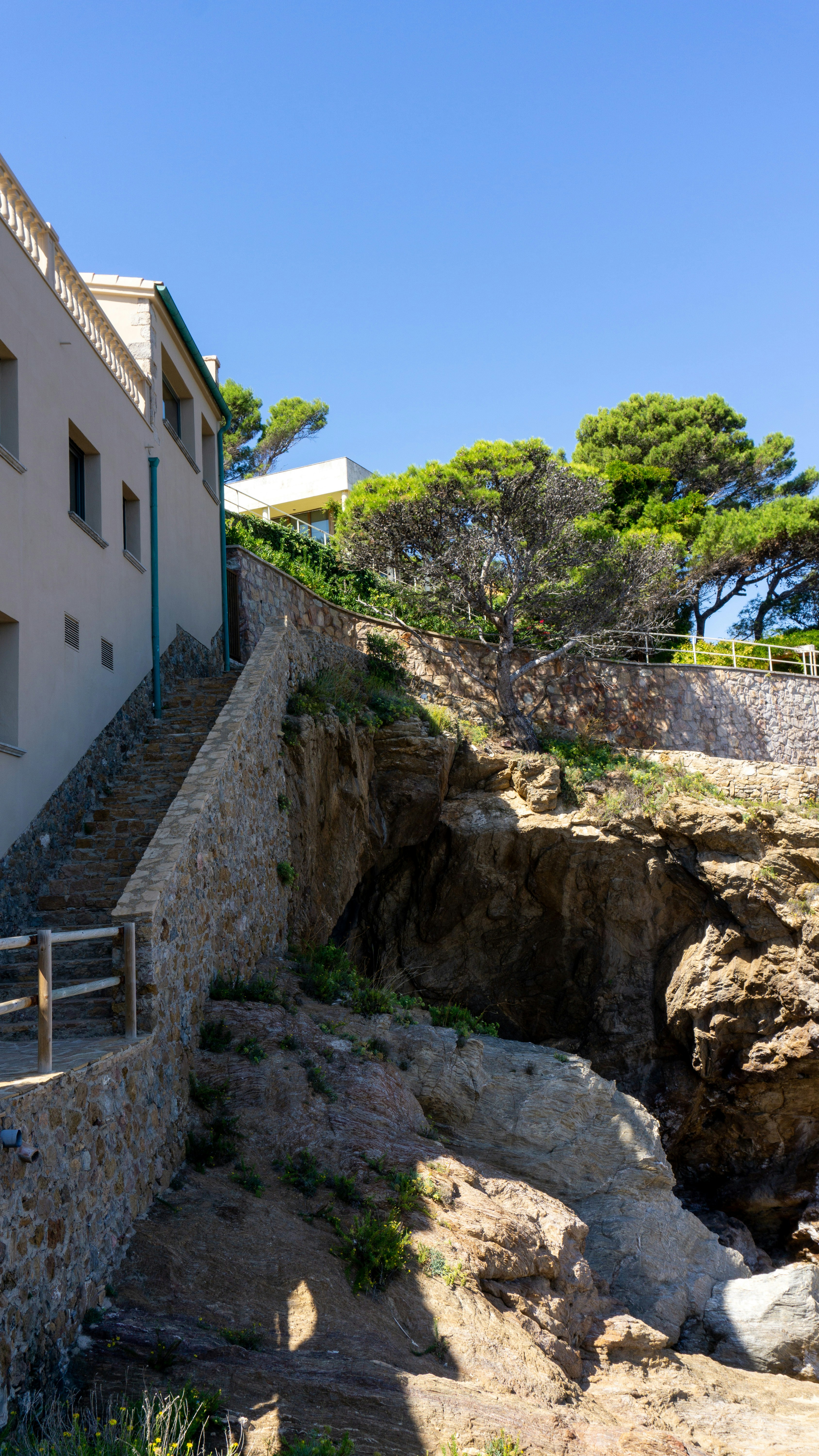 Cliffside Staircase by a Quiet Modern House Under a Clear Blue Sky