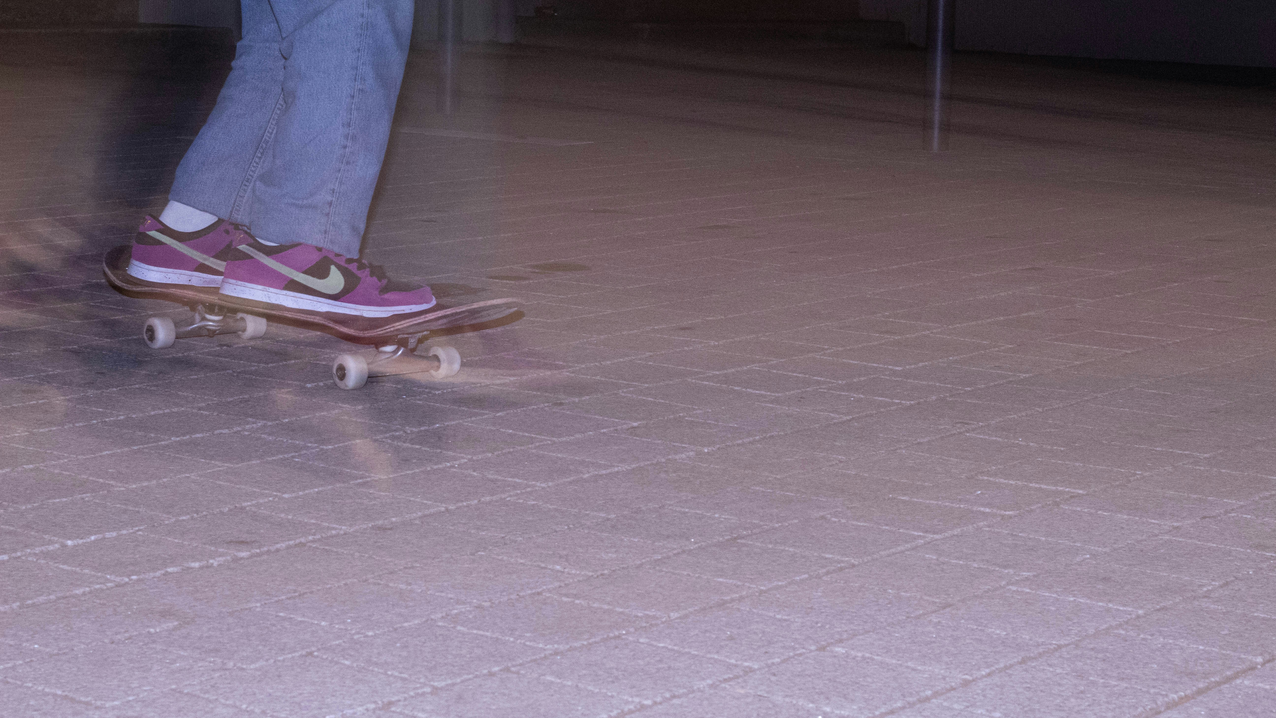 a person riding a skateboard on a tiled floor