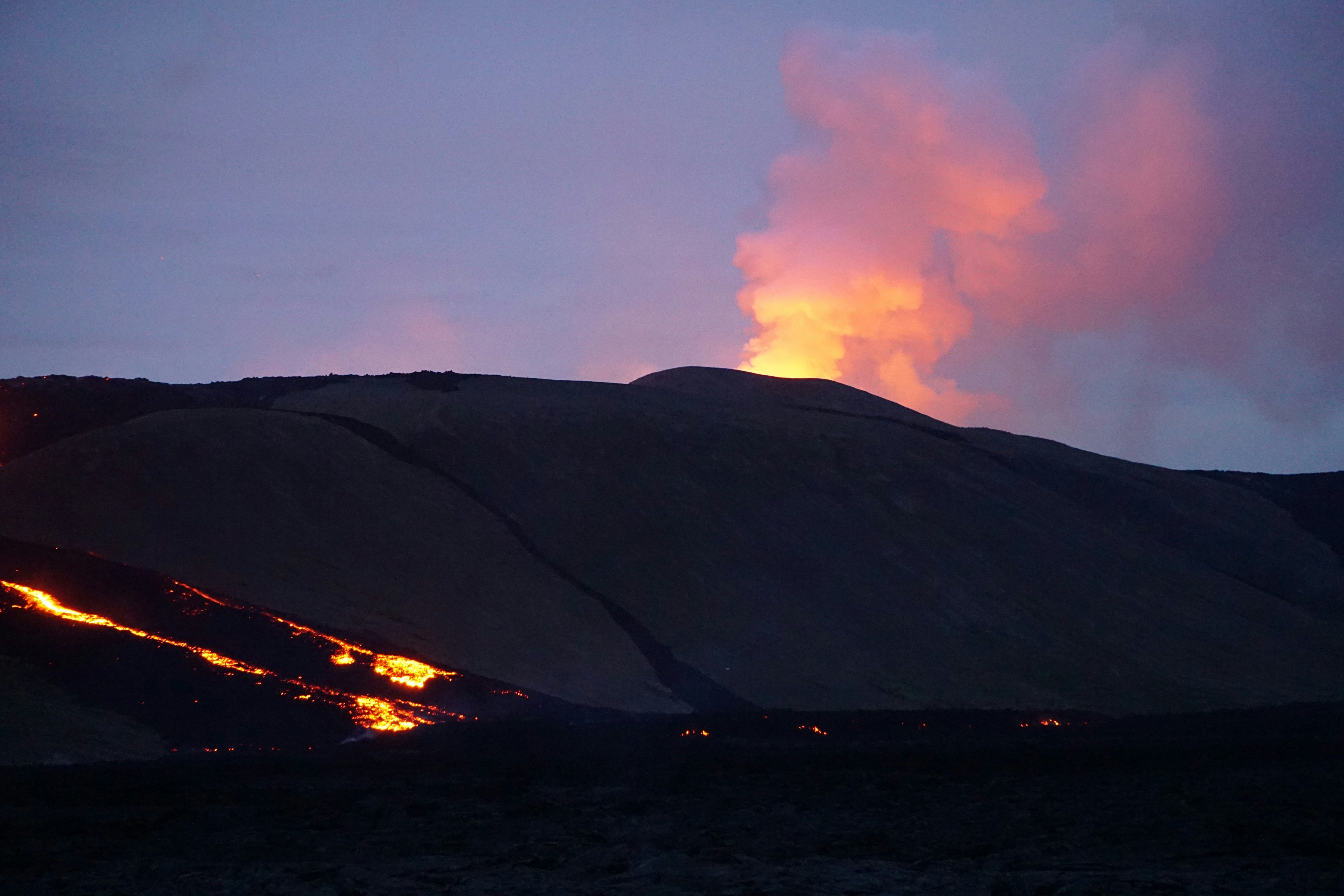 A fire blazing in the sky over a mountain photo – Free Iceland Image on ...