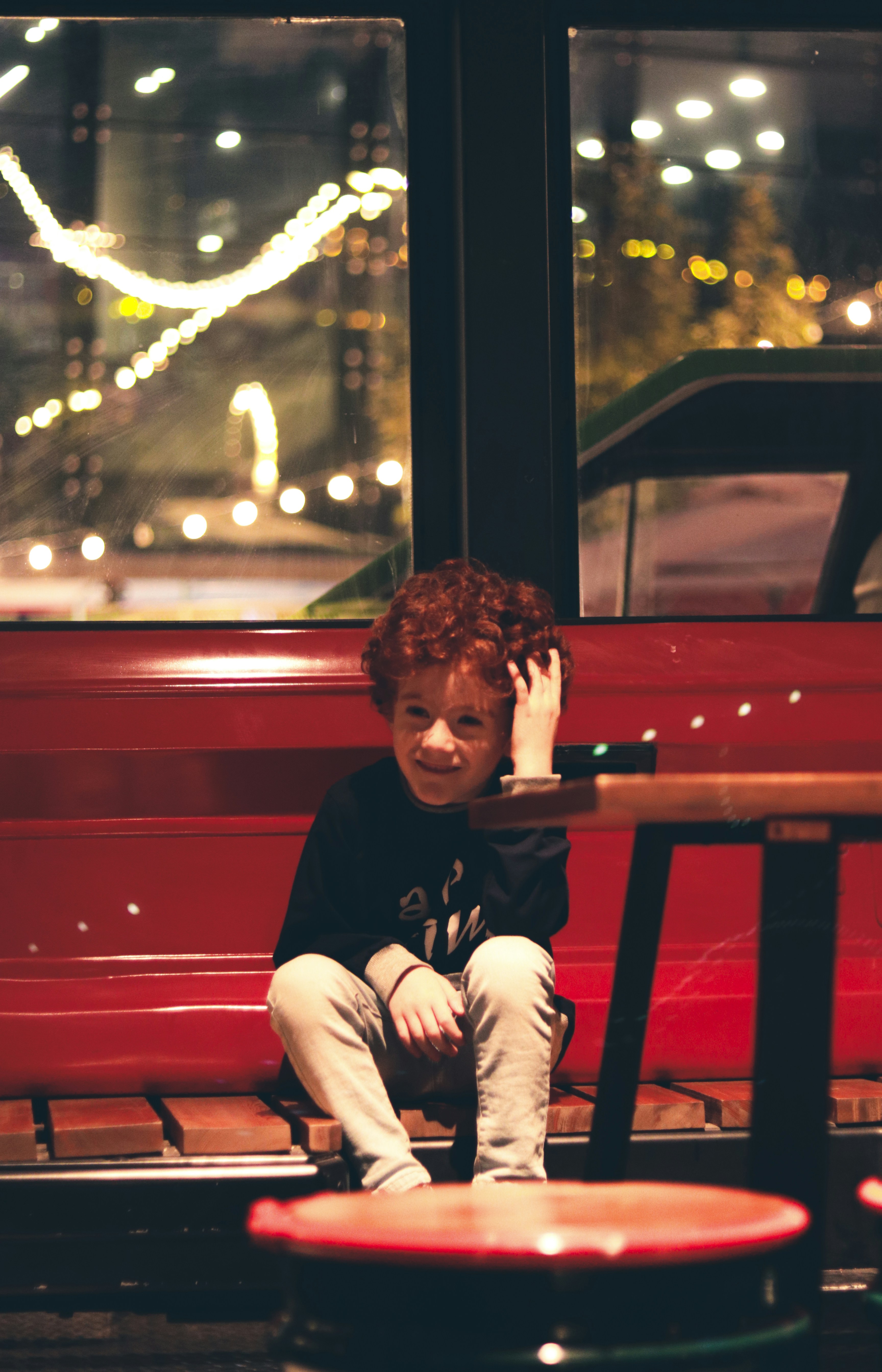 Nightglow on a Red Tram: A Boy's Quiet Moment