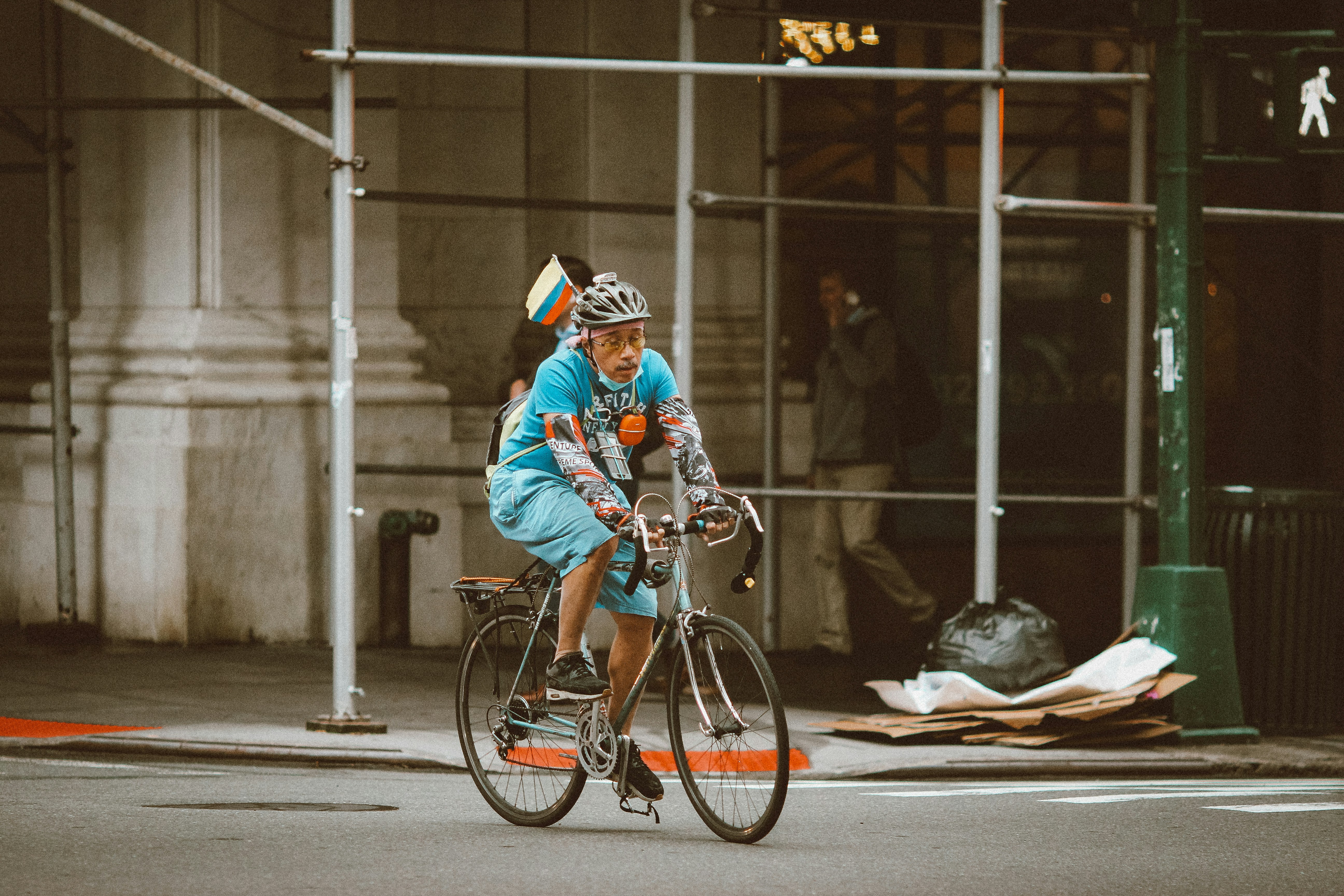 Teal-Clad Cyclist Navigates a Scaffolded City Street