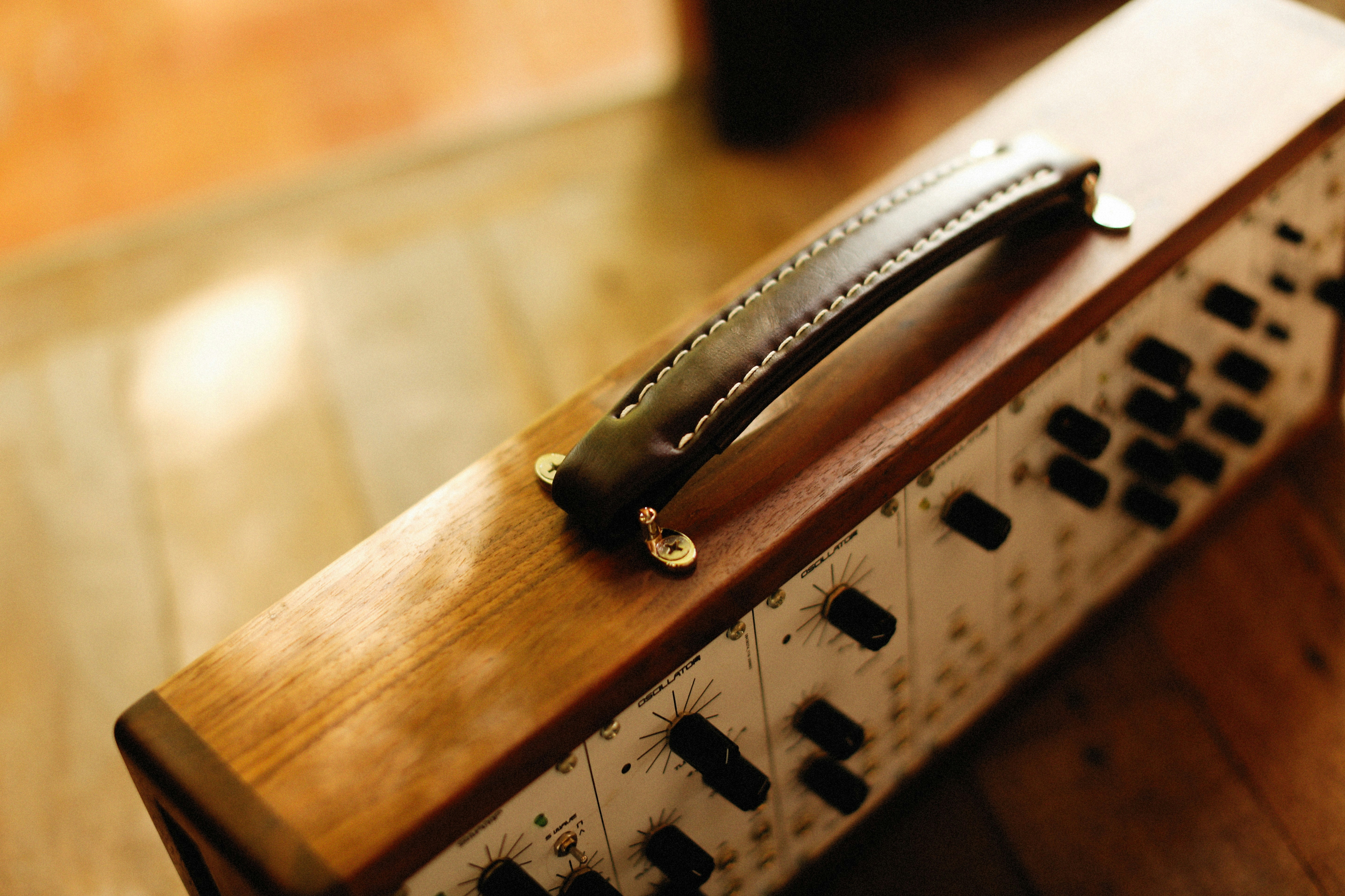 Leather Handle on a Vintage Wooden Amp: A Close-Up in Warm Light
