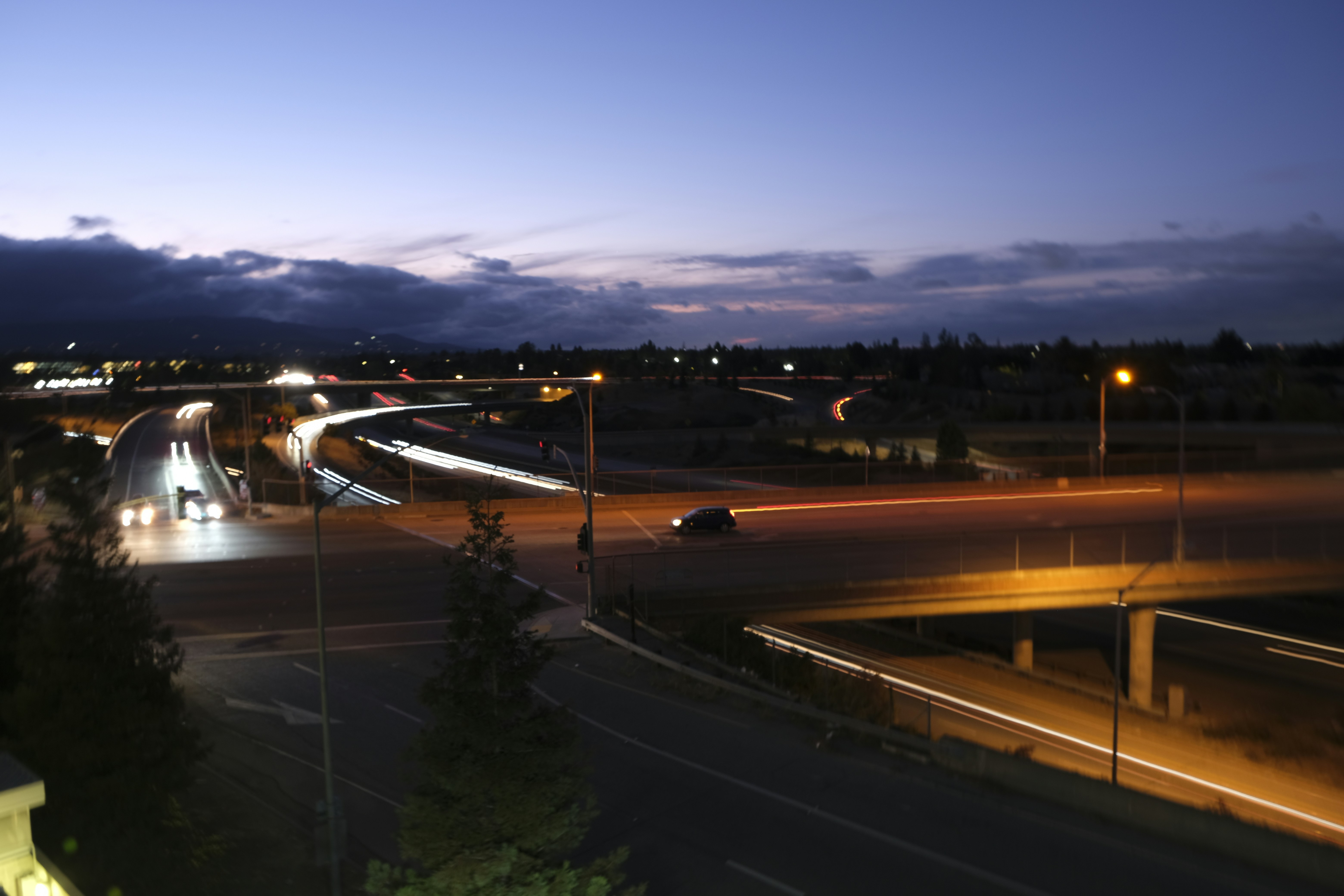 a city street at night with cars driving on it