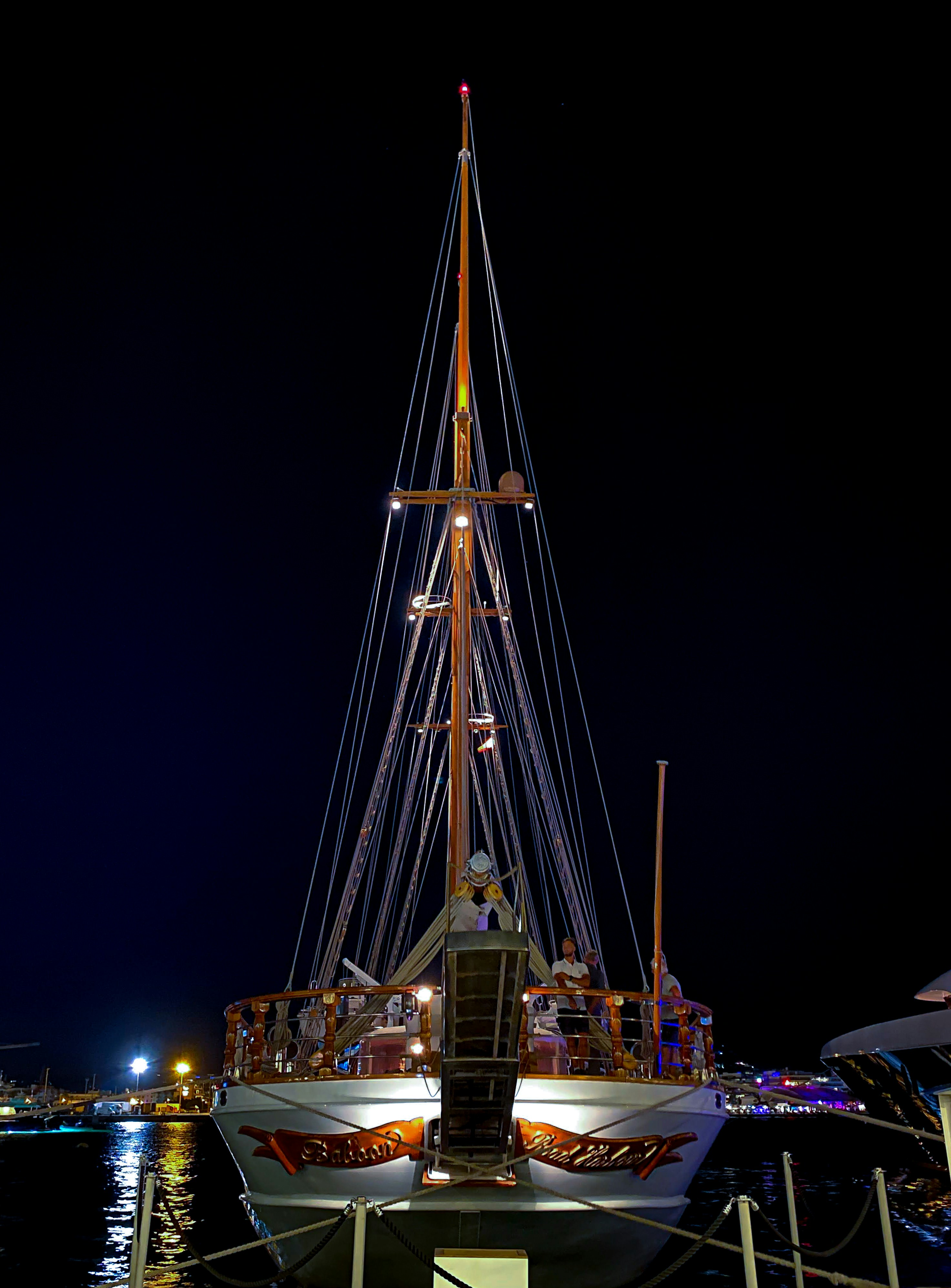 Nocturnal Mast: Lantern-Glow Sailboat Resting at the Dock