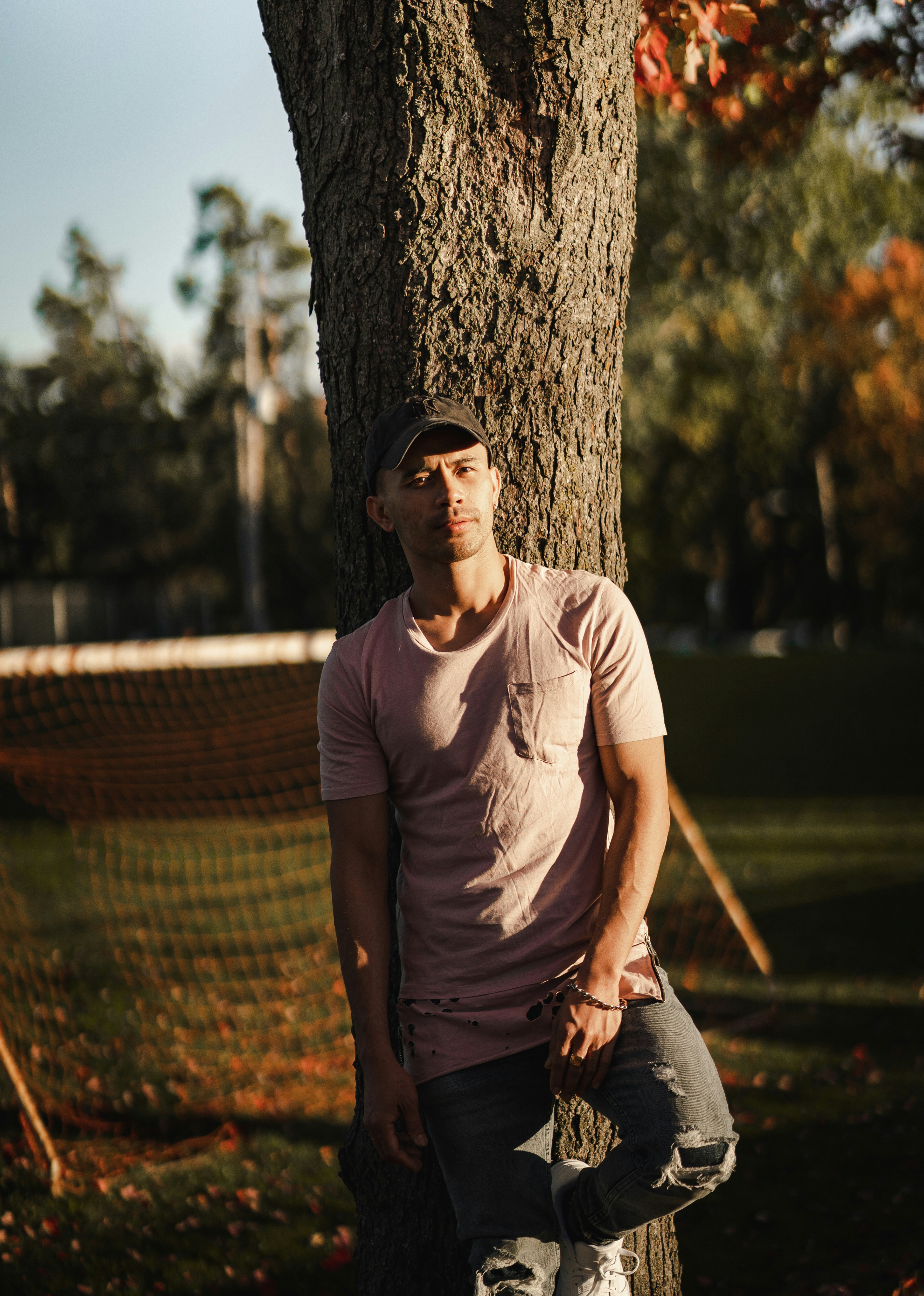 A man leaning against a tree in a park photo – Free Human Image on Unsplash