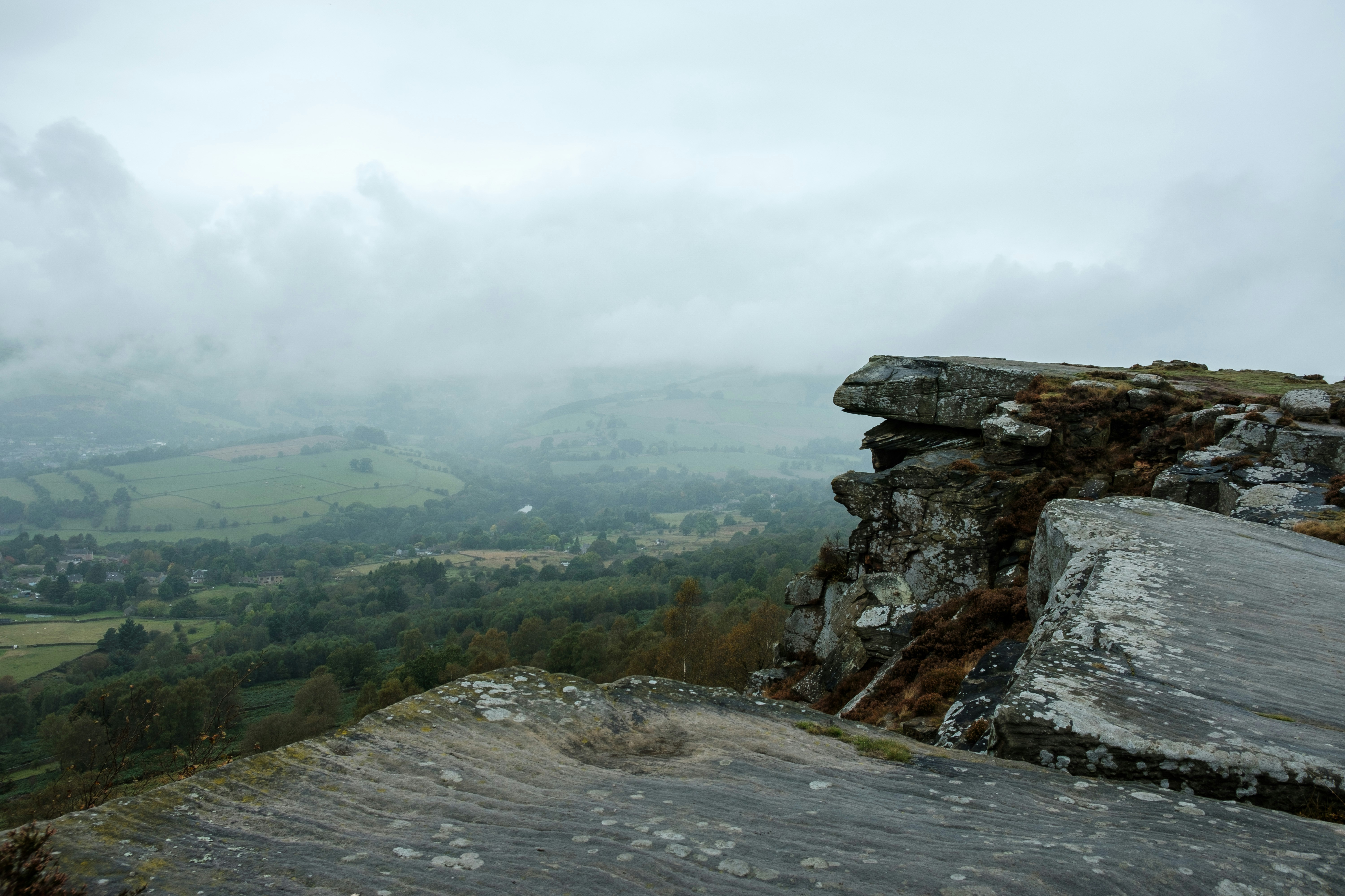 A rocky outcropping with a valley in the distance photo – Free Curbar ...