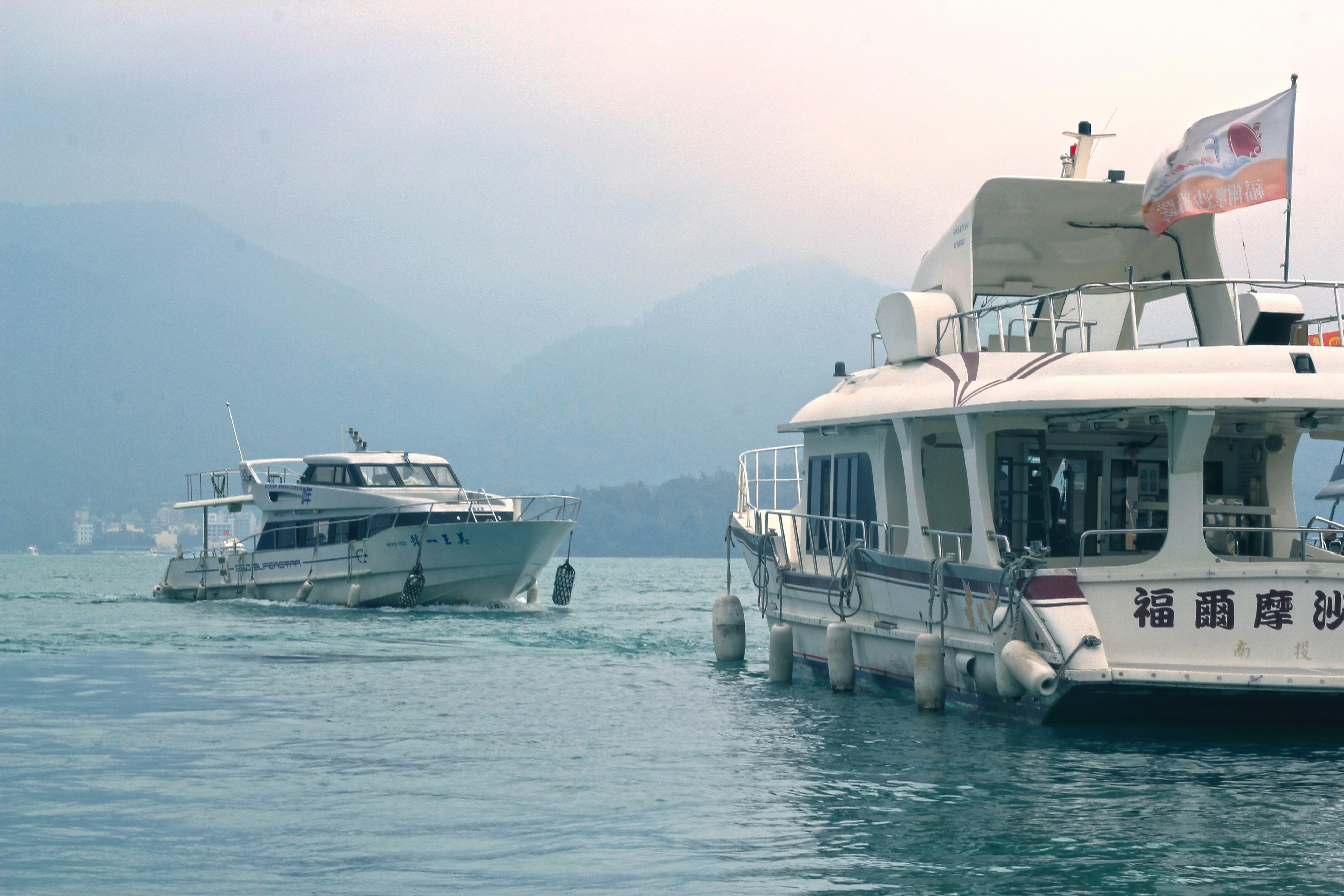 Docked calm: a pair of passenger boats guarding the morning mist