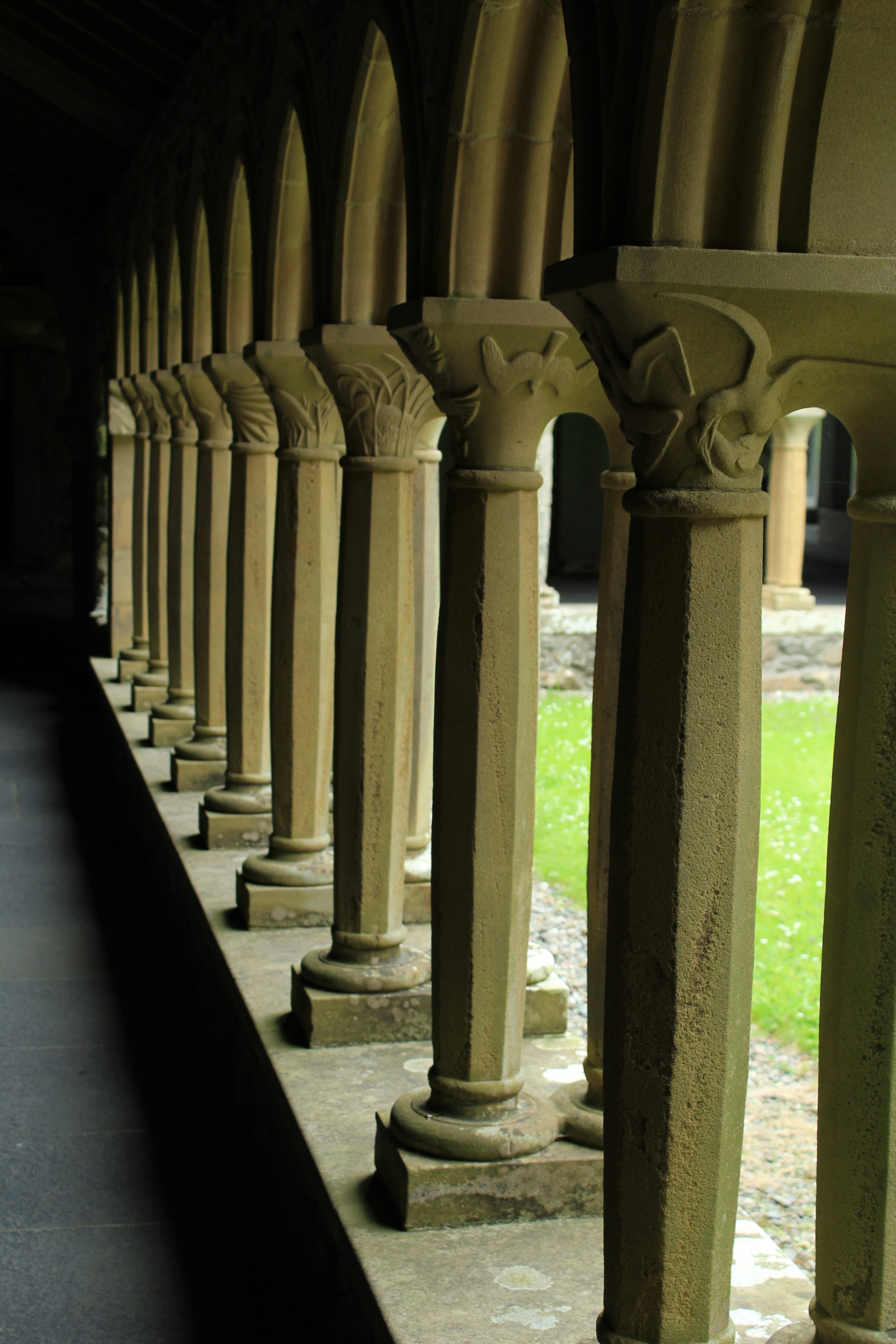 a row of stone pillars sitting next to a lush green field