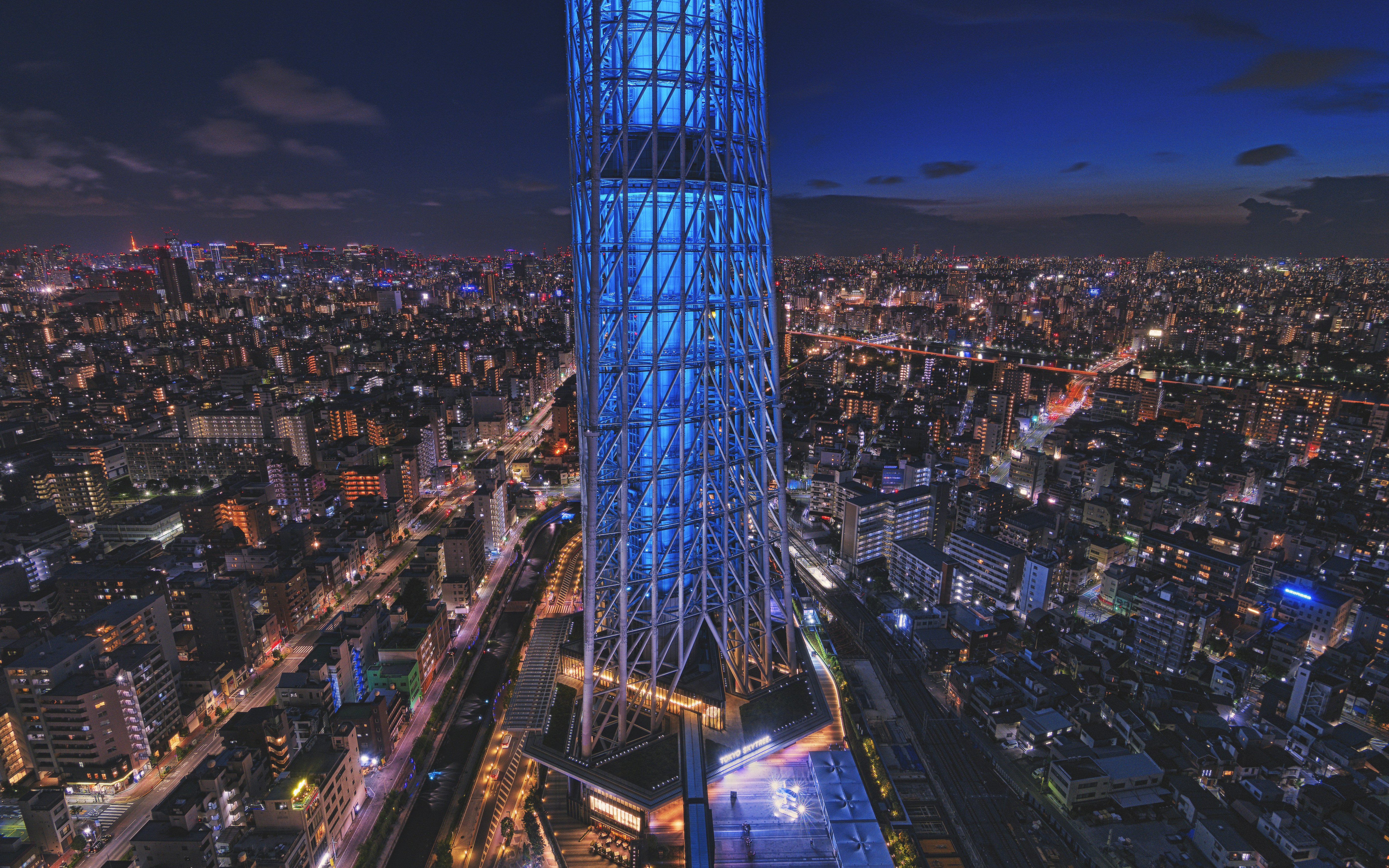Blue Tower Looms Over a Neon-Spangled City