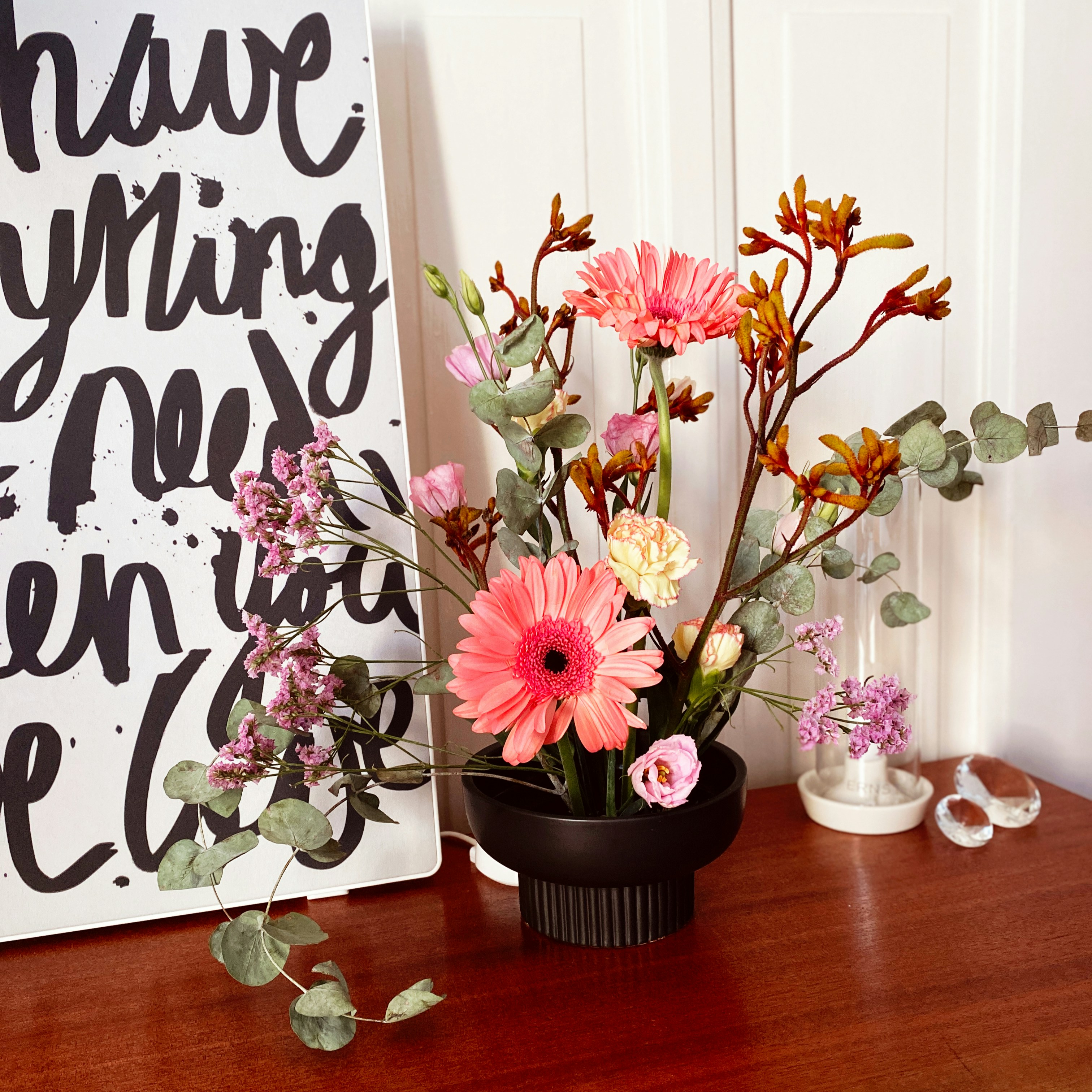 Petal Portrait on a Walnut Surface: Pink Gerberas and Eucalyptus Take Center Stage