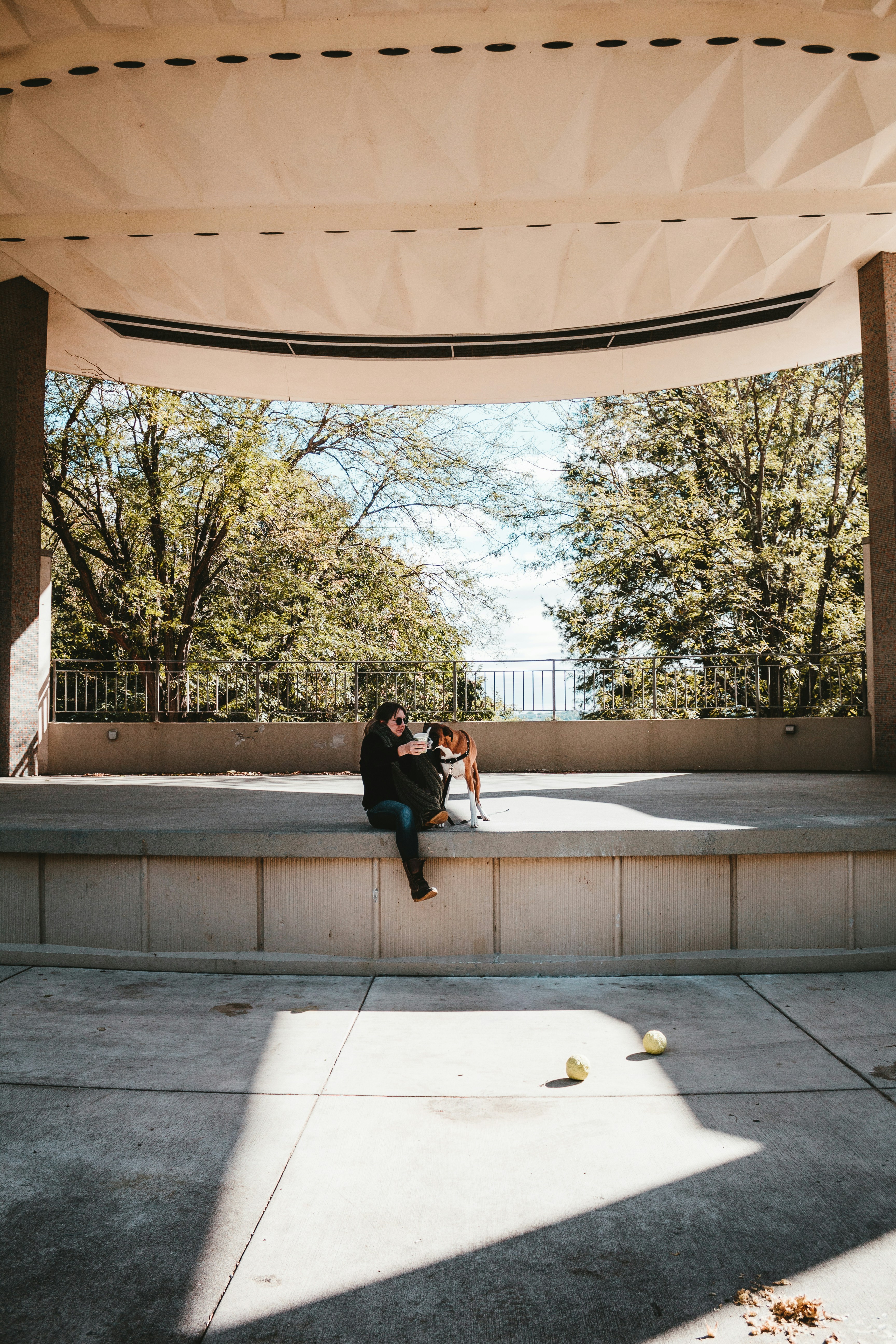 Couple on a sunlit stage: quiet moment beneath an open-air canopy