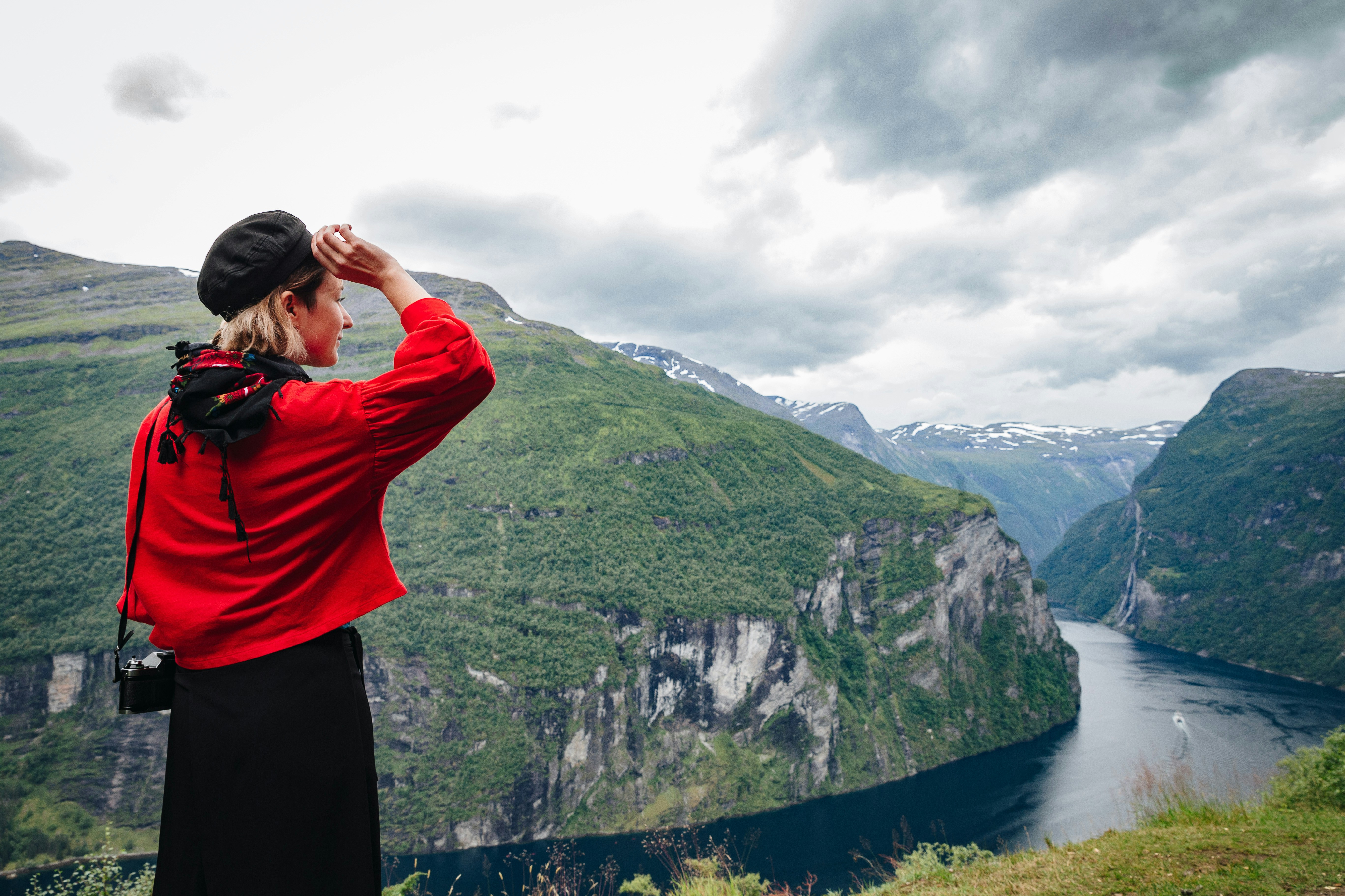 Red Jacket at the Edge: Gazing Across a Verdant Fjord