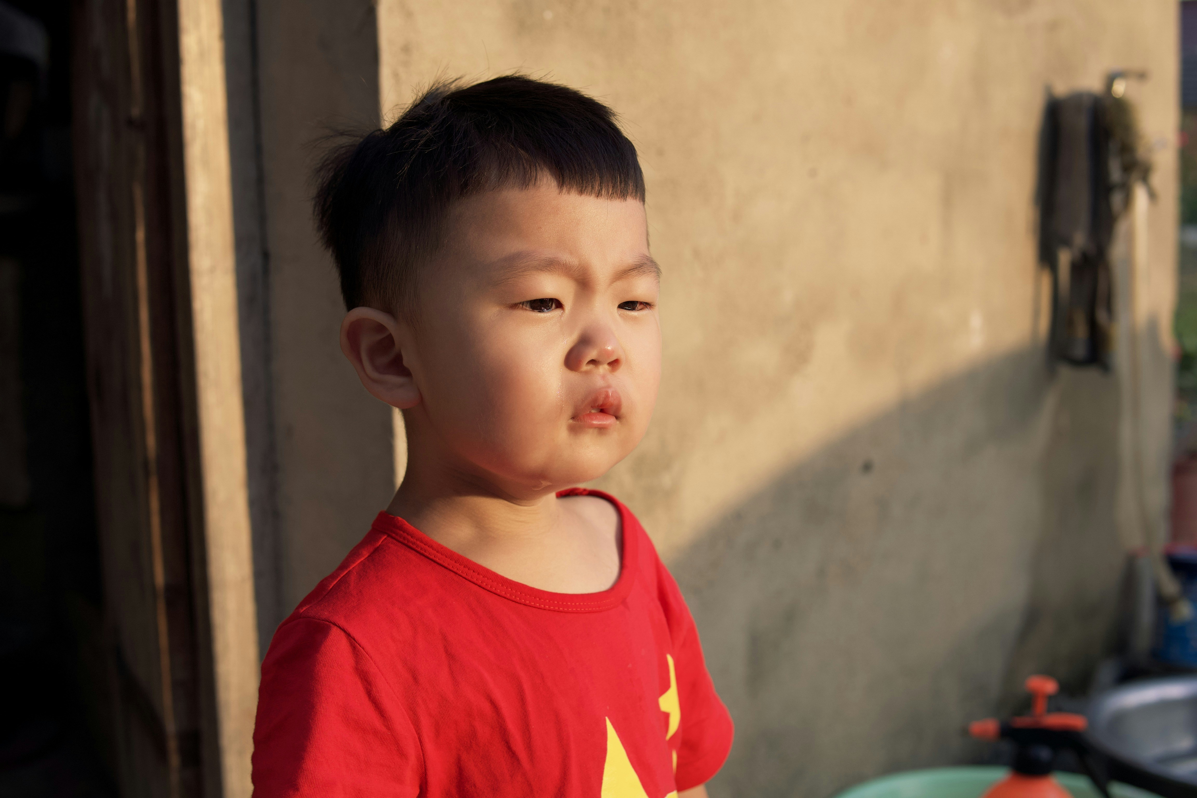 A young boy standing in front of a building photo – Free Person Image ...