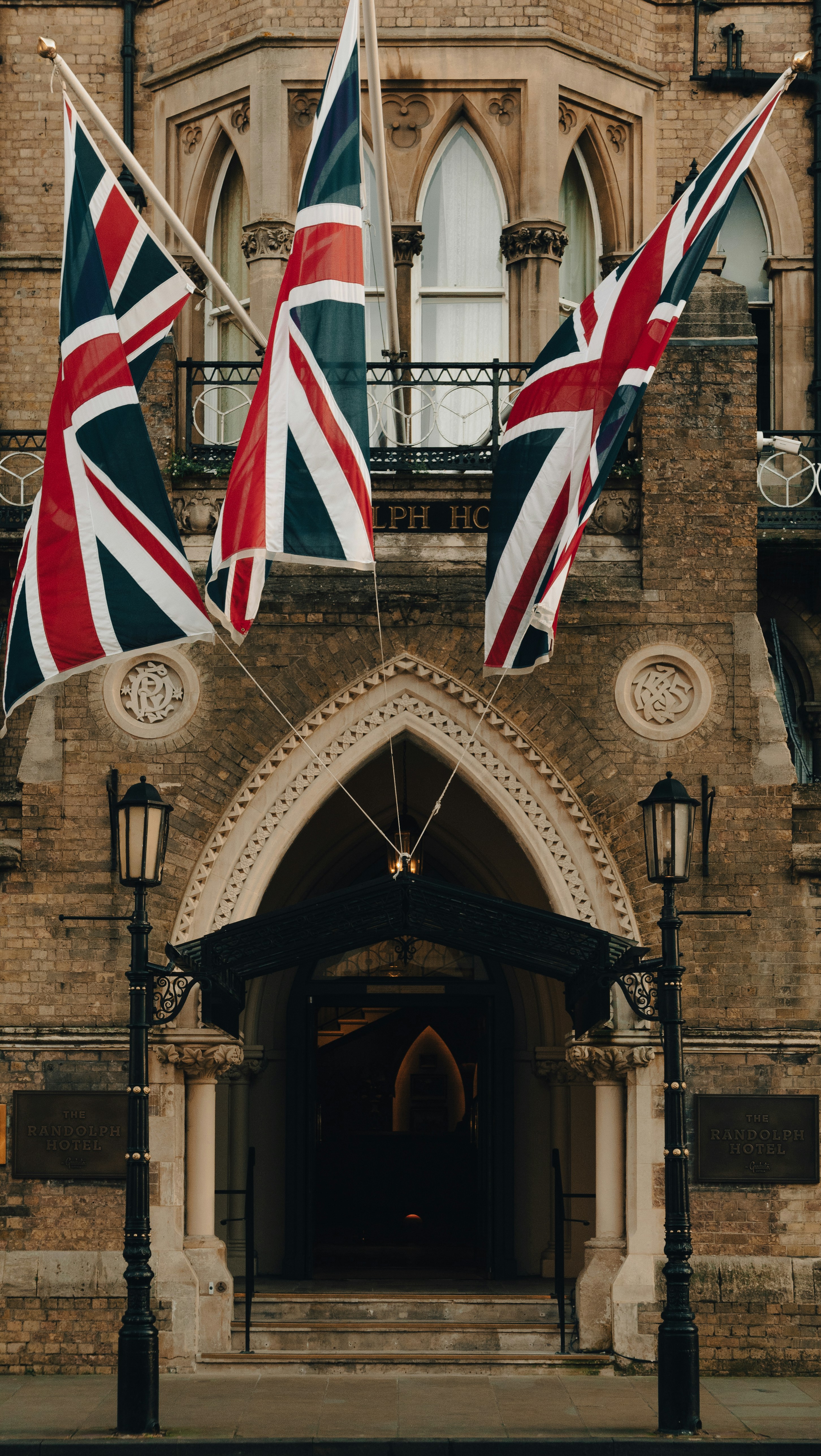 Union Flags Framing a Brick-Arch Hotel Entrance