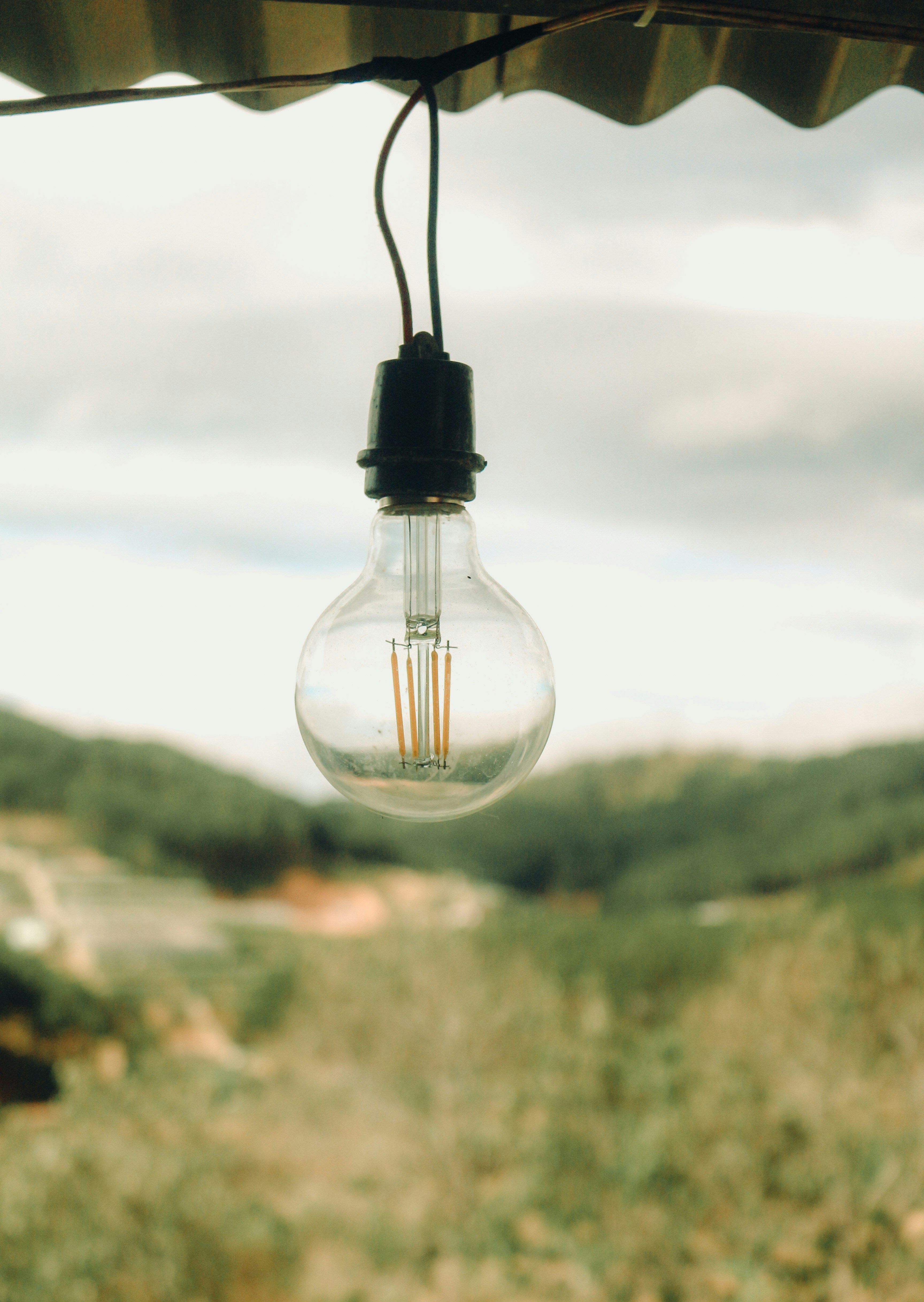 A light bulb hanging from the side of a roof photo – Free Light Image ...