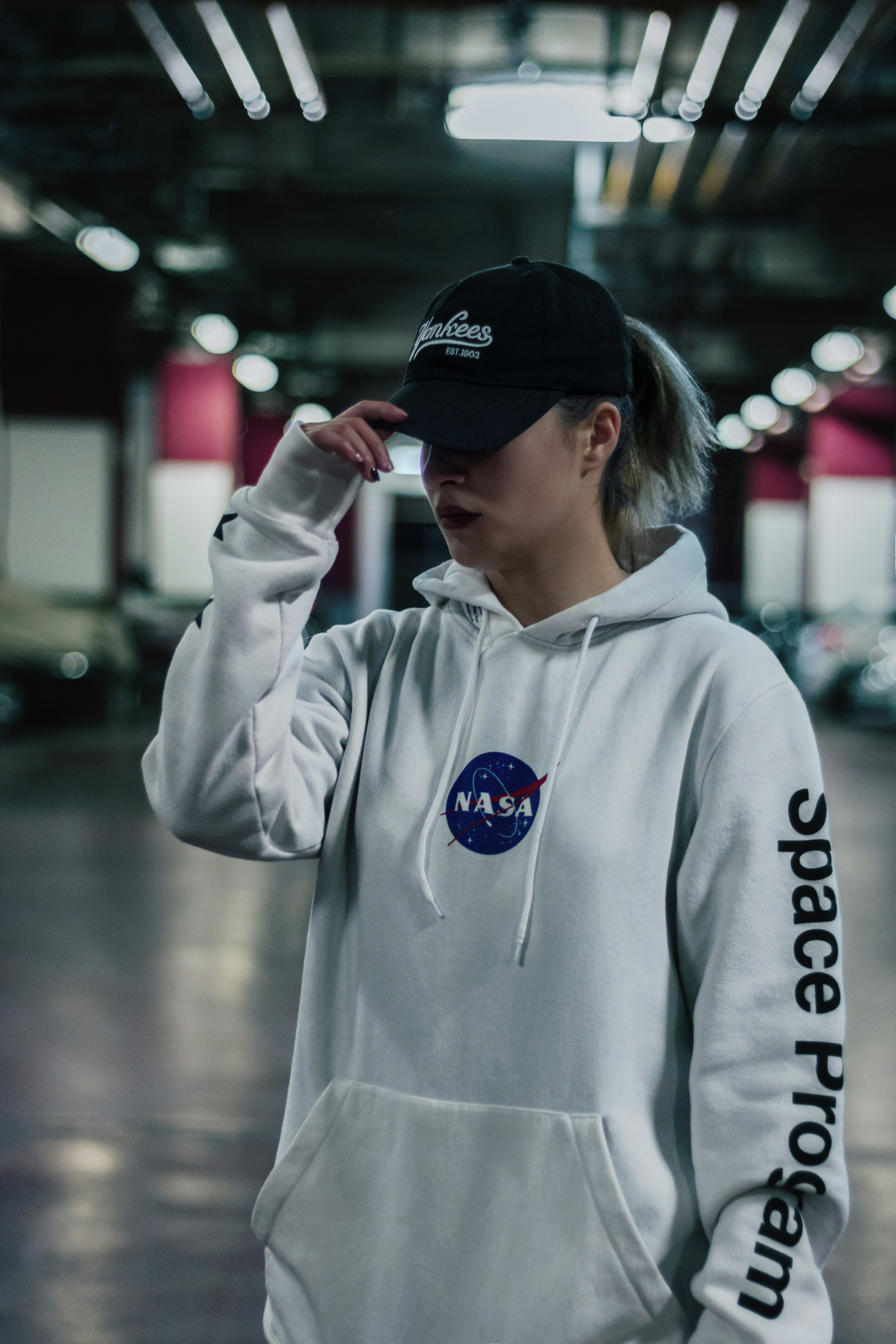NASA hoodie in a dim parking garage under neon glow