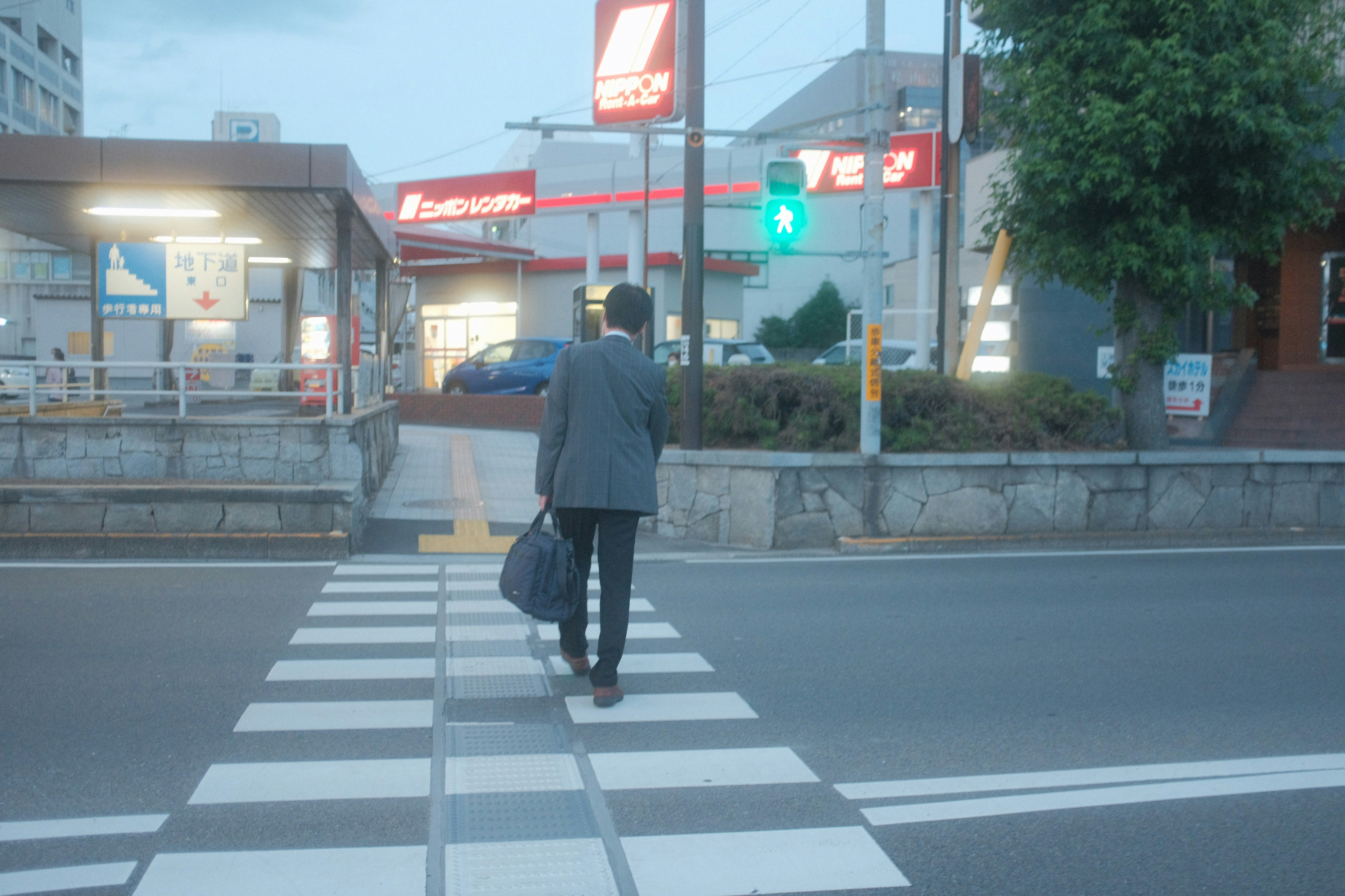 a man walking across a street holding a bag