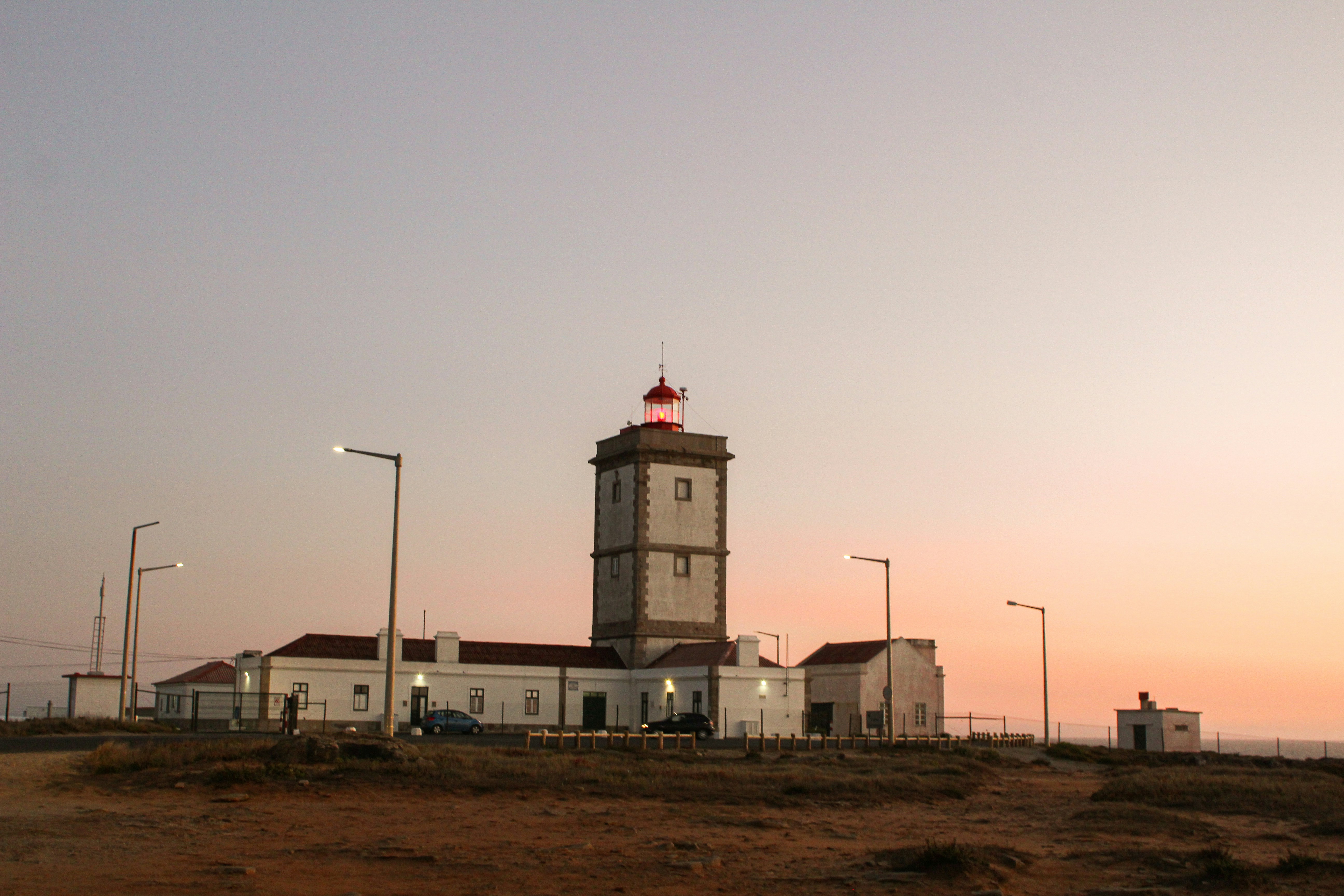 Dusk Beacon at the Dunes: A solitary lighthouse under a peach sky