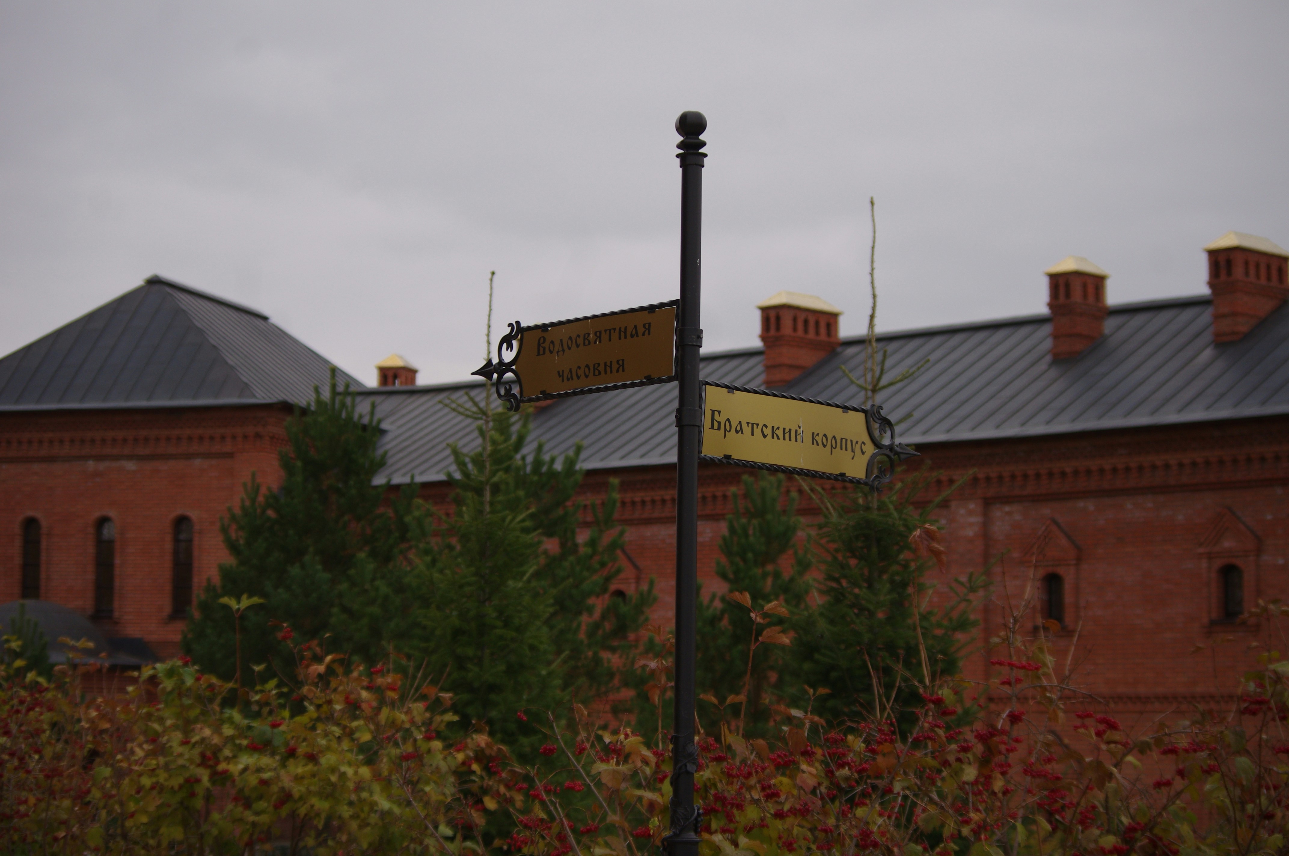 Vintage directional signposts in front of a historic brick building, surrounded by greenery. The scene evokes a sense of exploration and nostalgia.