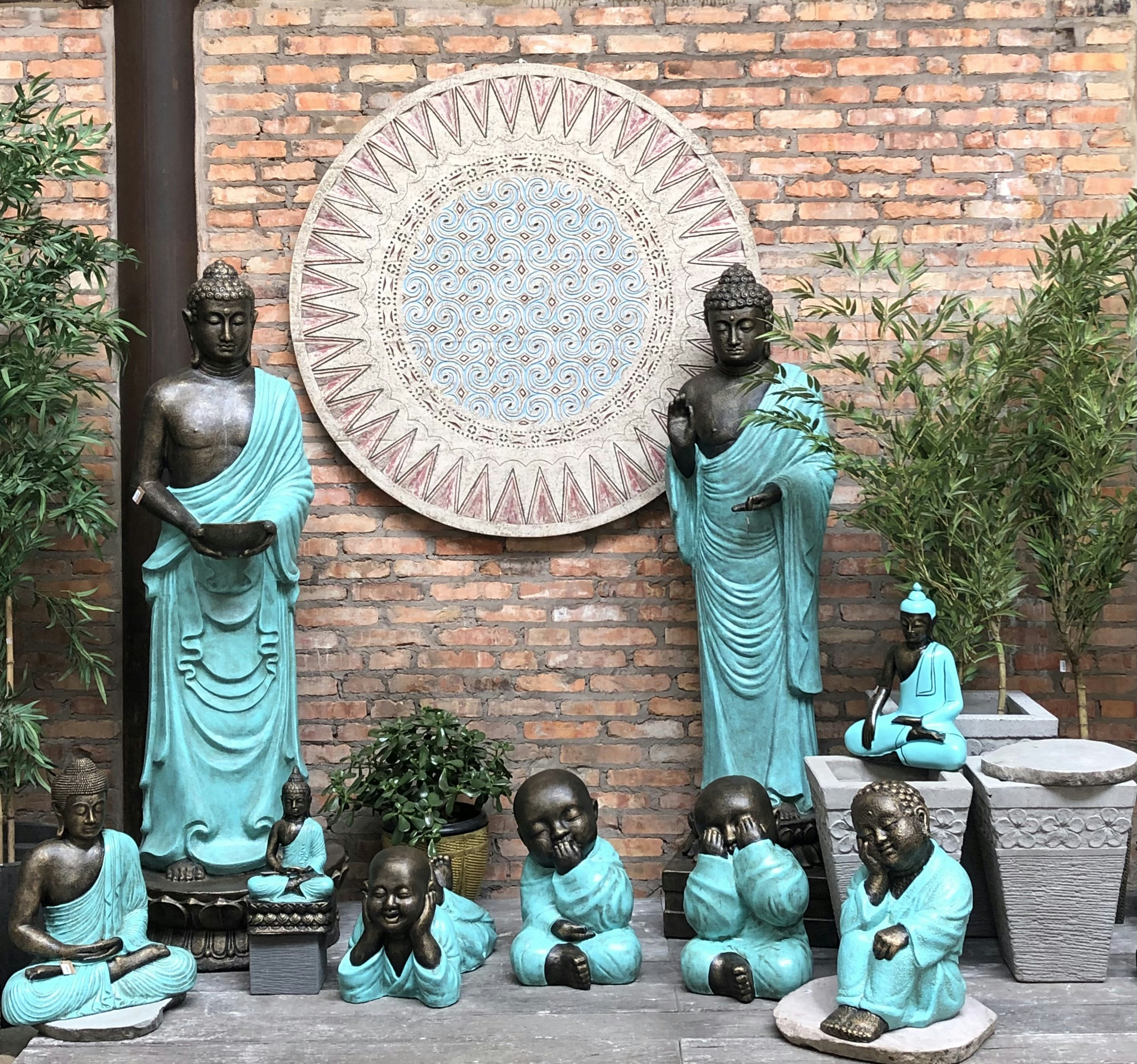 A group of statues sitting next to a brick wall photo – Free Worship ...