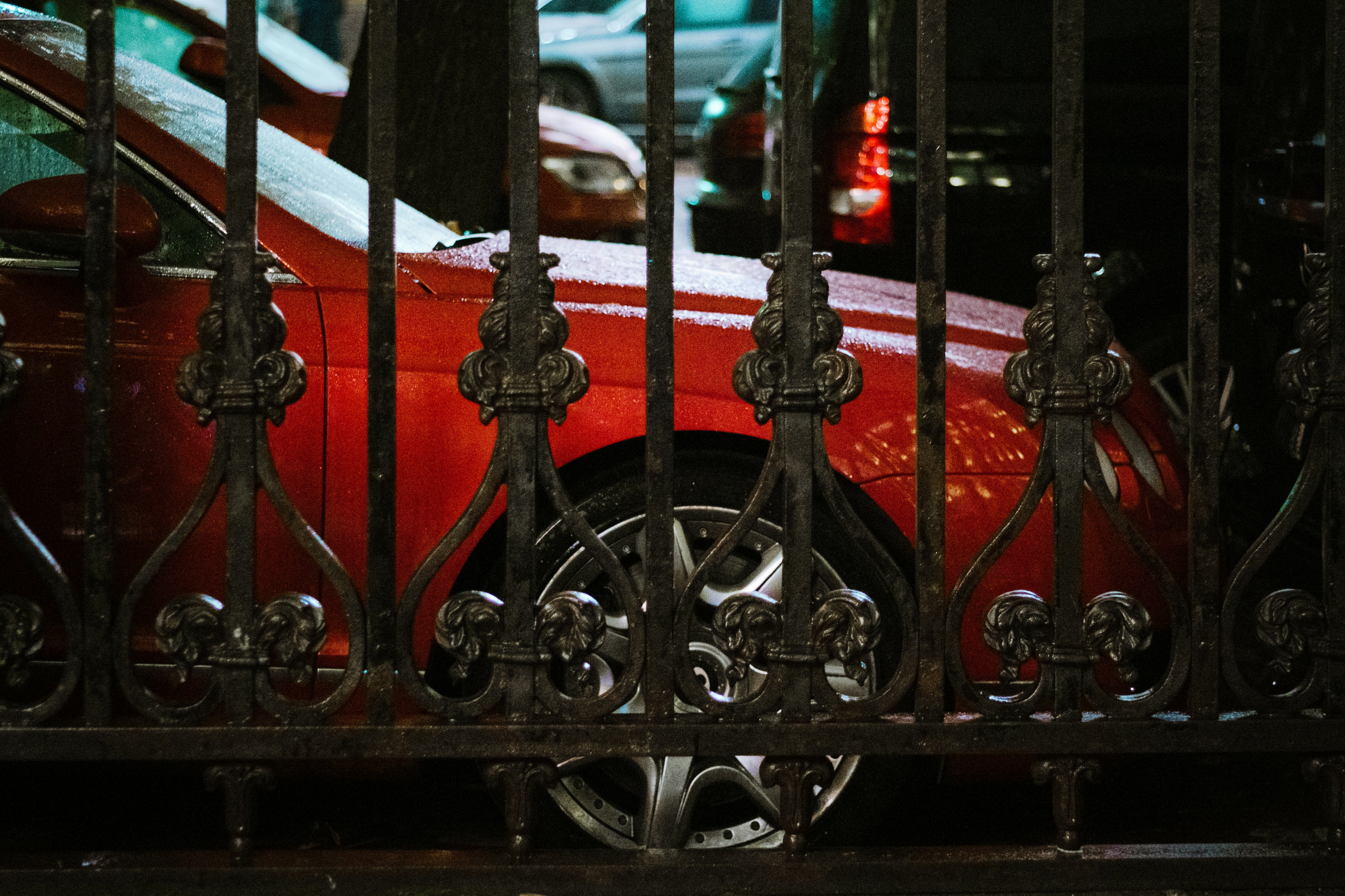 A red car behind a fence in a city photo – Free Car Image on Unsplash