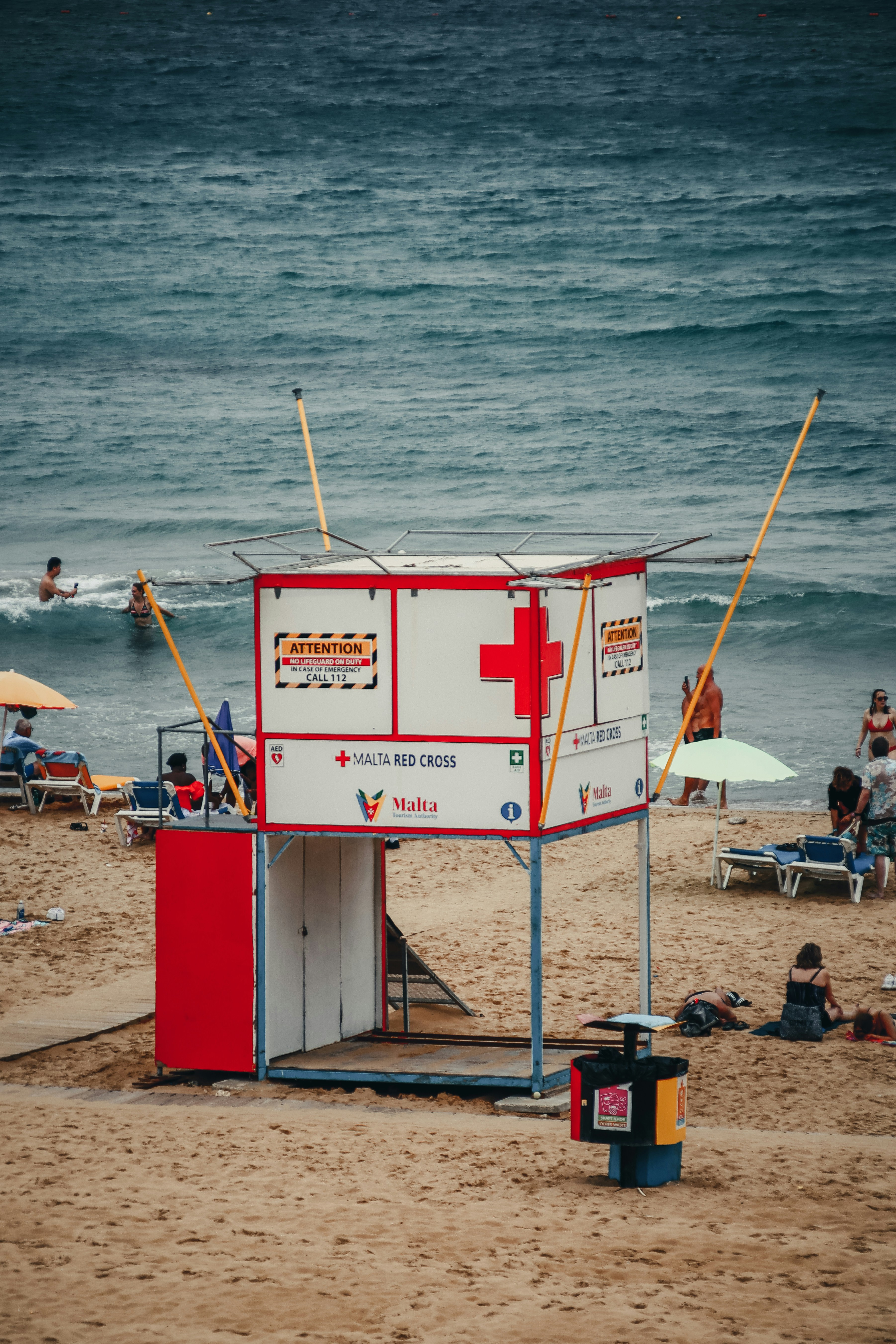 A lifeguard station on the beach with people in the water photo – Free ...