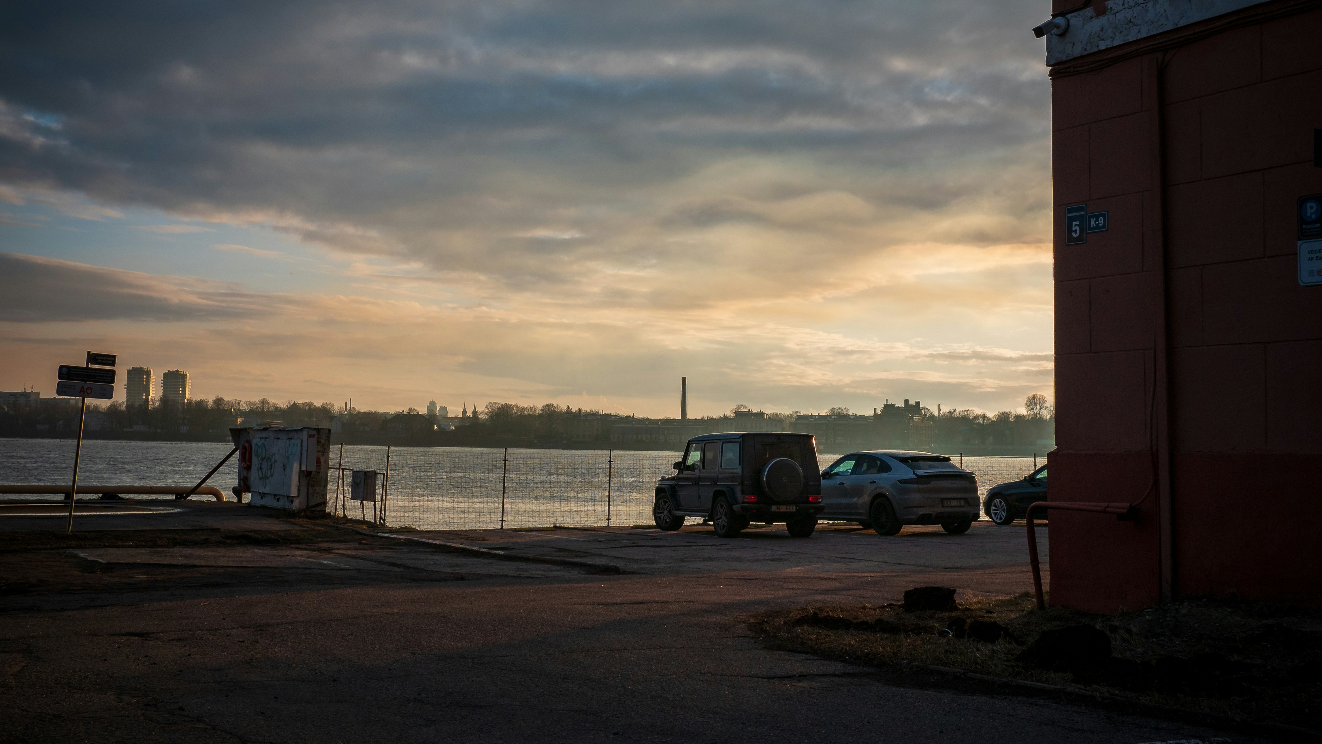 a truck parked next to a building near a body of water