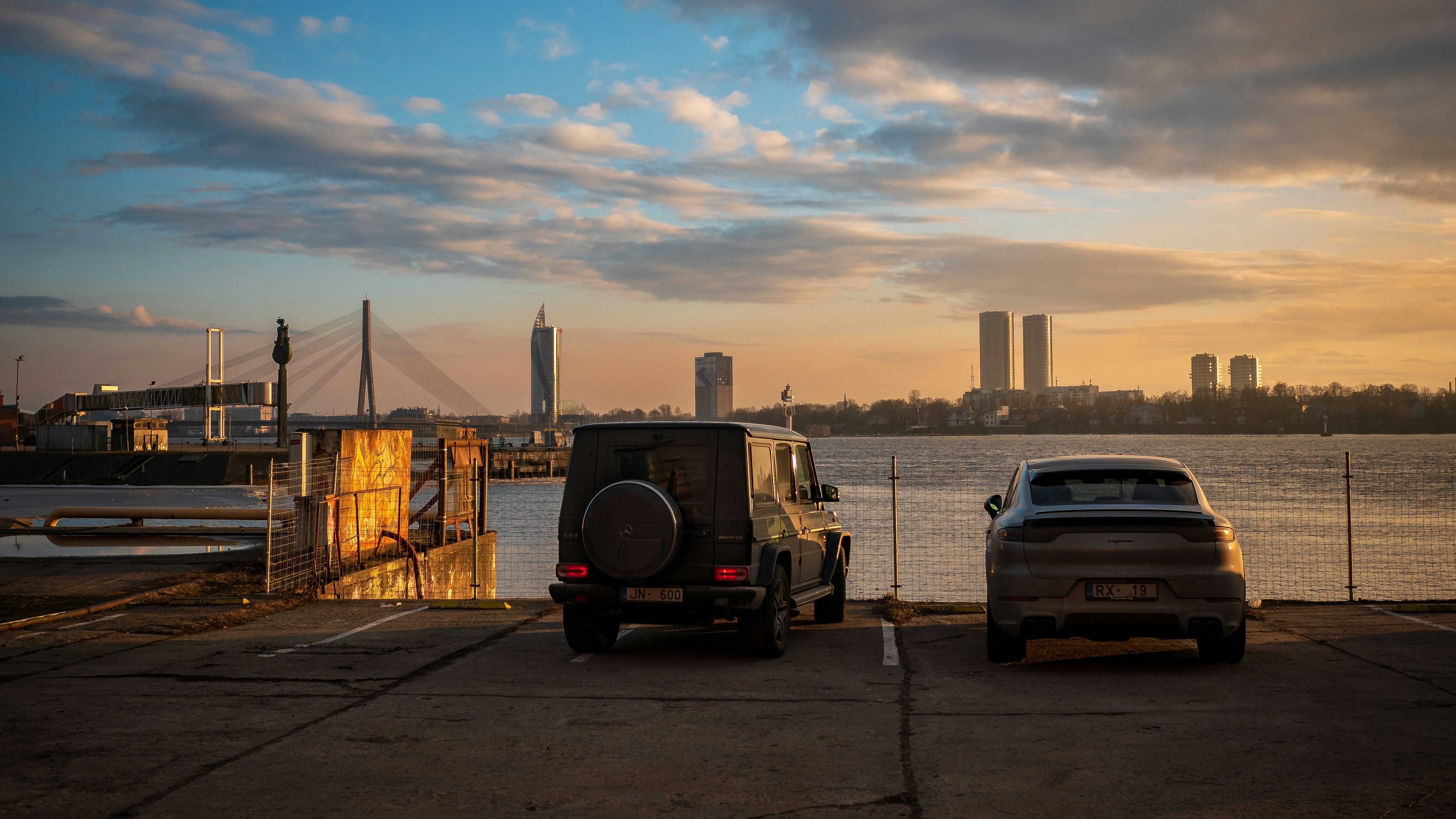 two cars parked next to each other near a body of water