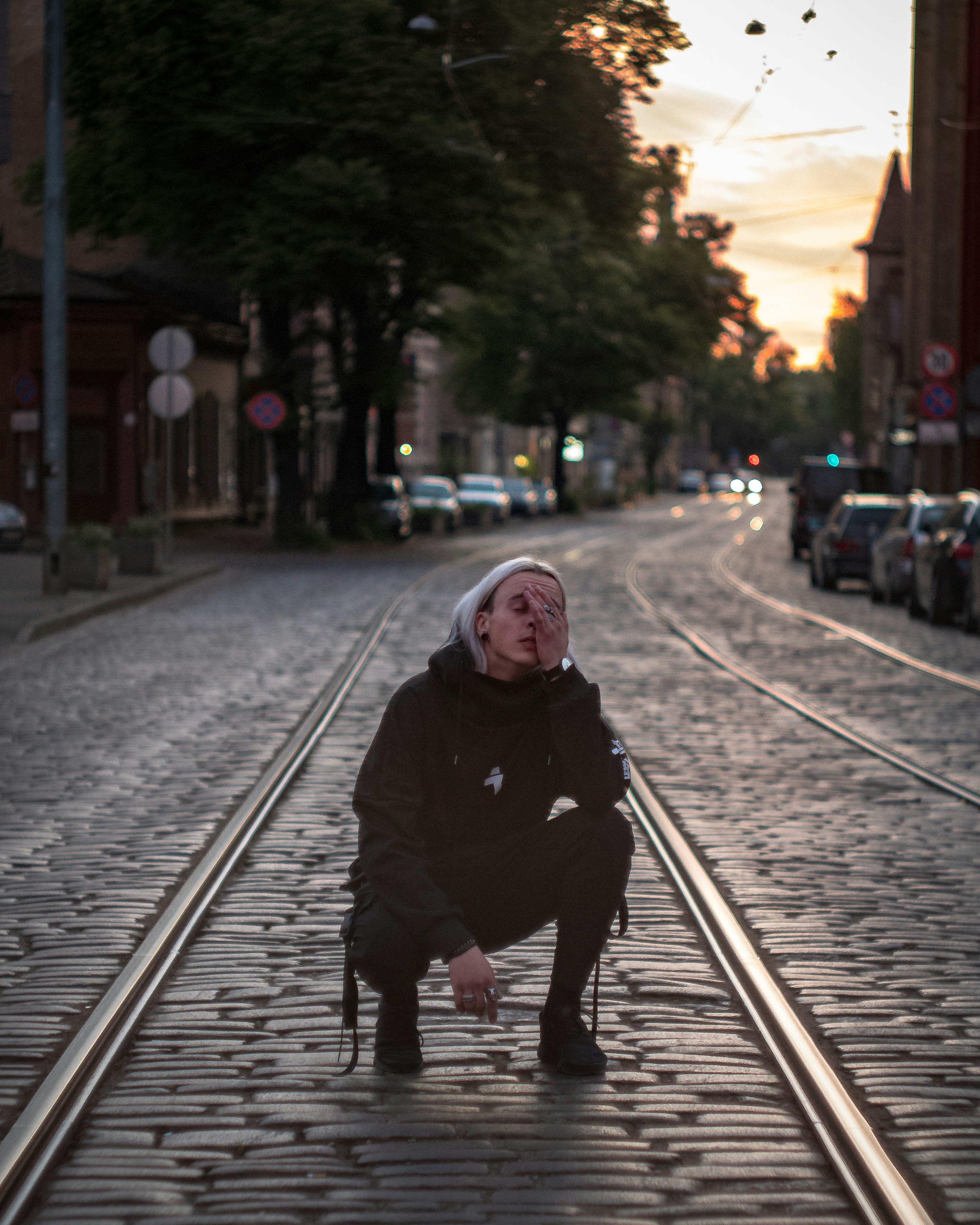 Midstreet Portrait: A Weathered Moment on Wet Cobblestones