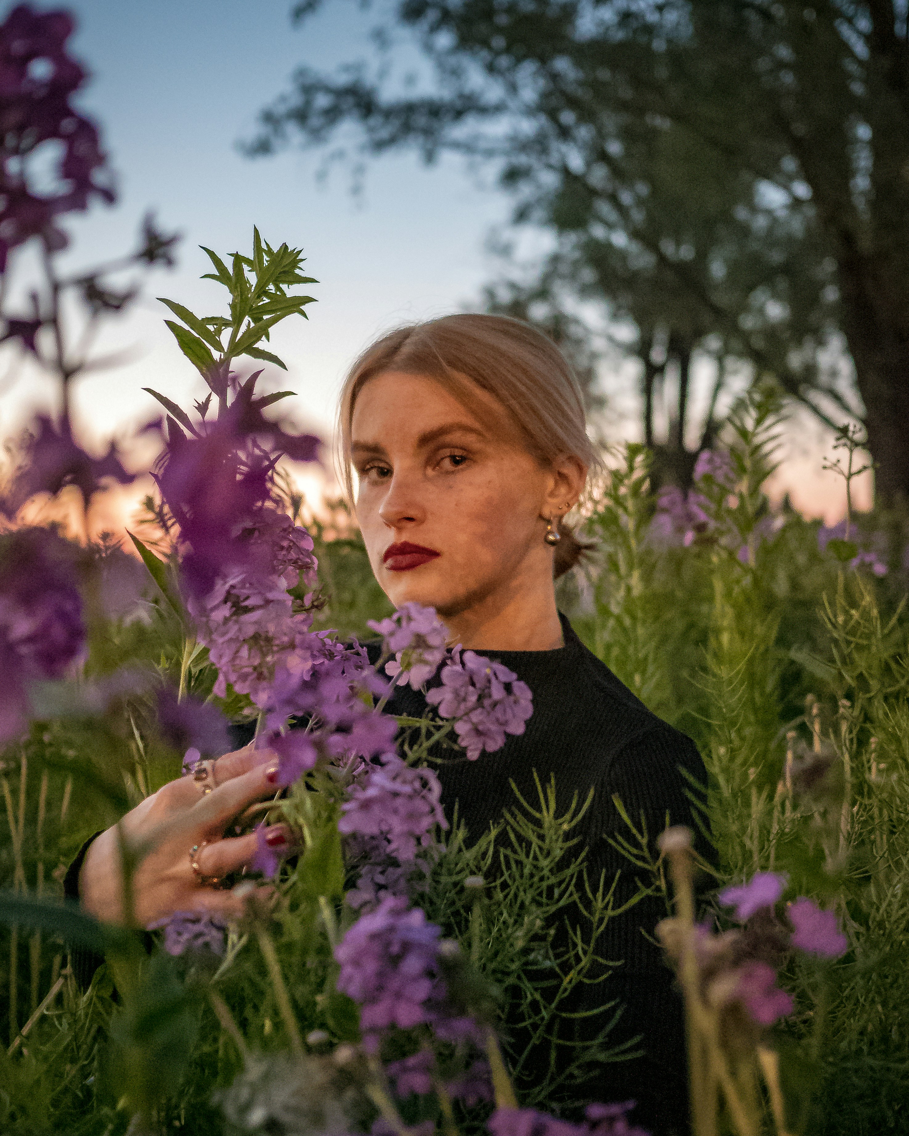 Dusk Portrait Amid Purple Blooms: A Quiet Gaze Among Tall Flowers