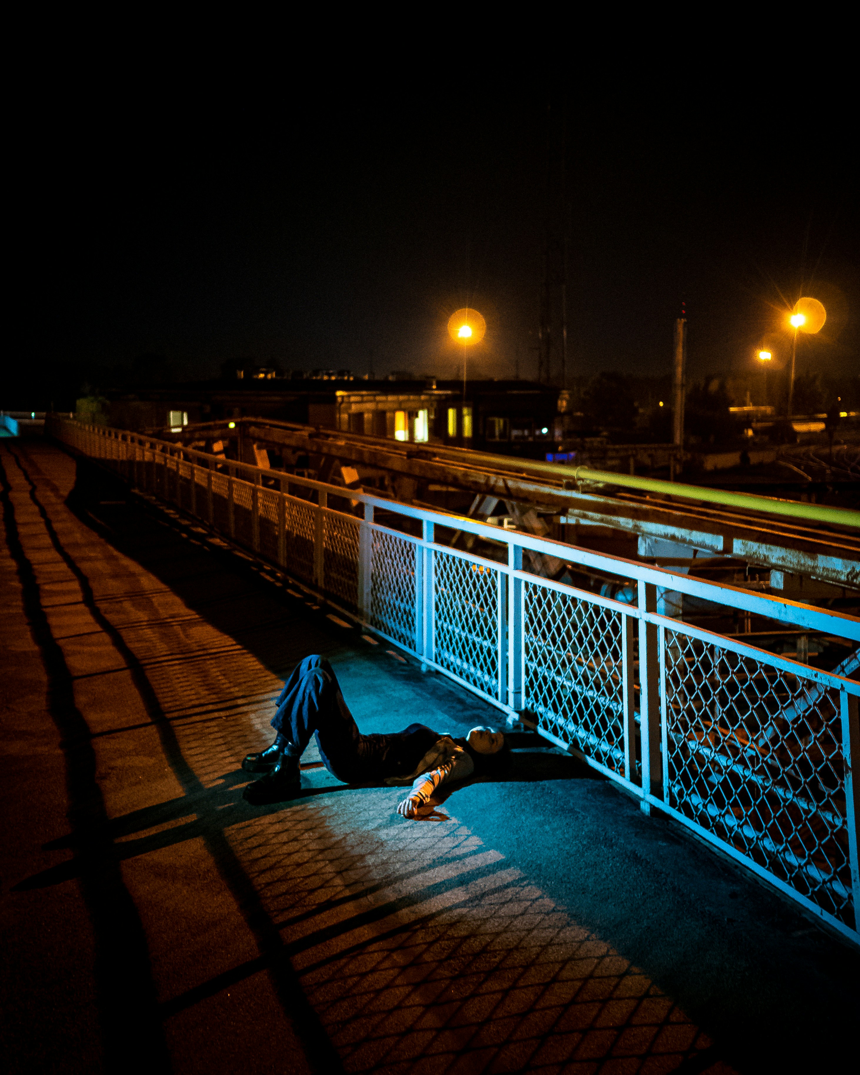 A person laying on the ground next to a fence photo – Free Human Image ...