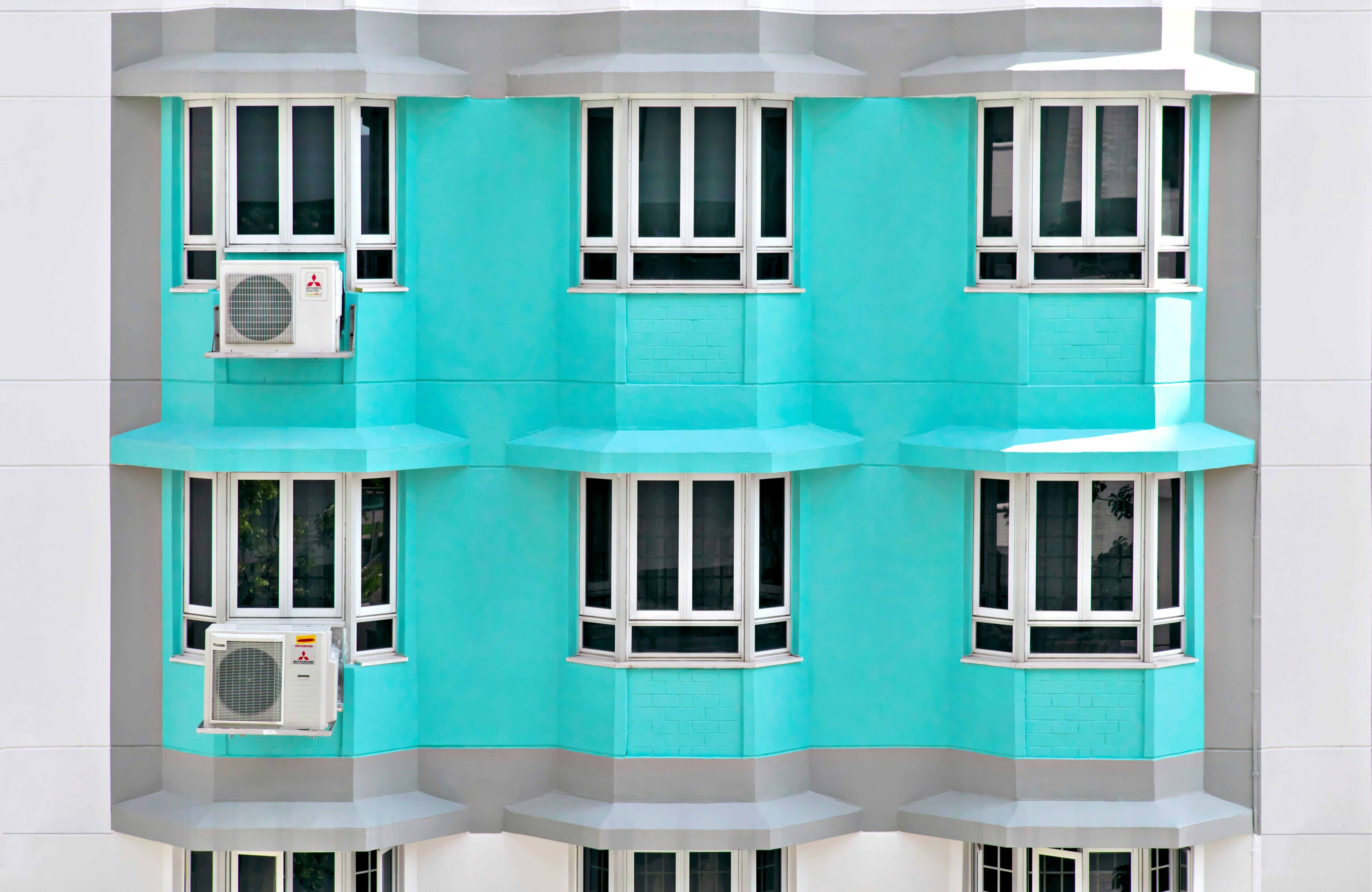 Turquoise Facade with Recessed Windows and Air-Conditioners