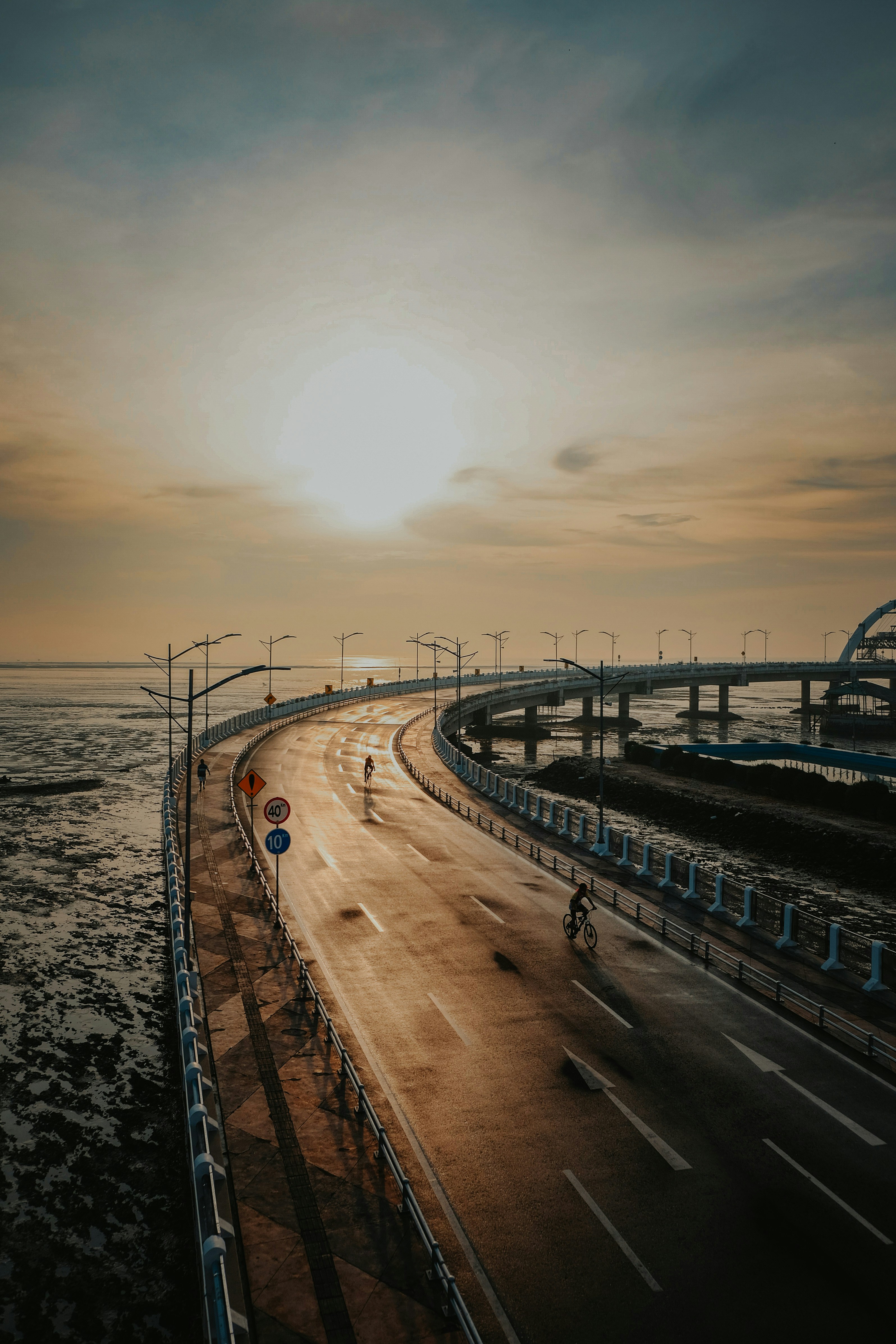 Morning Ride  | the sun is setting over a highway near the ocean